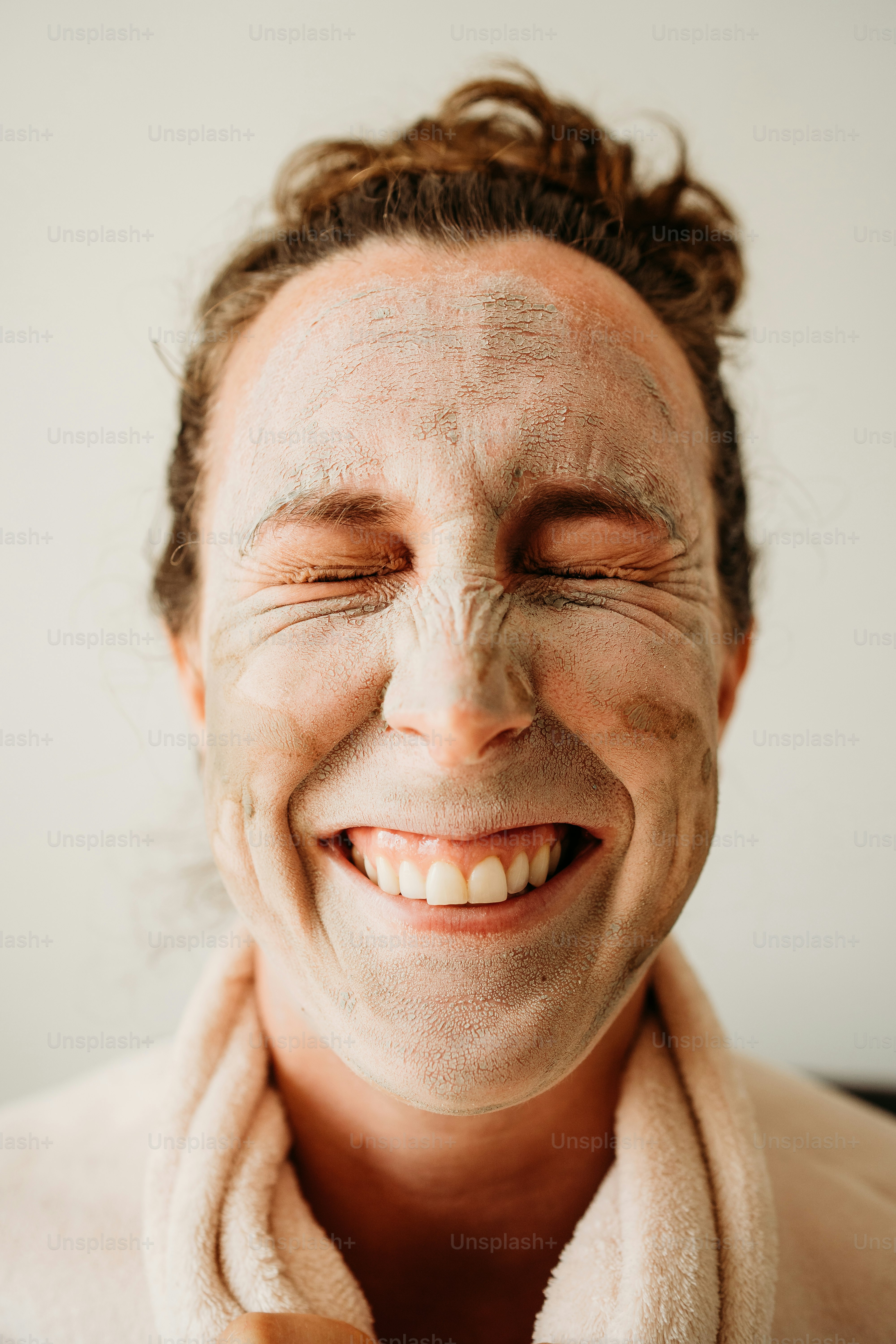 A woman with a towel around her neck smiling photo – Beauty Image on ...