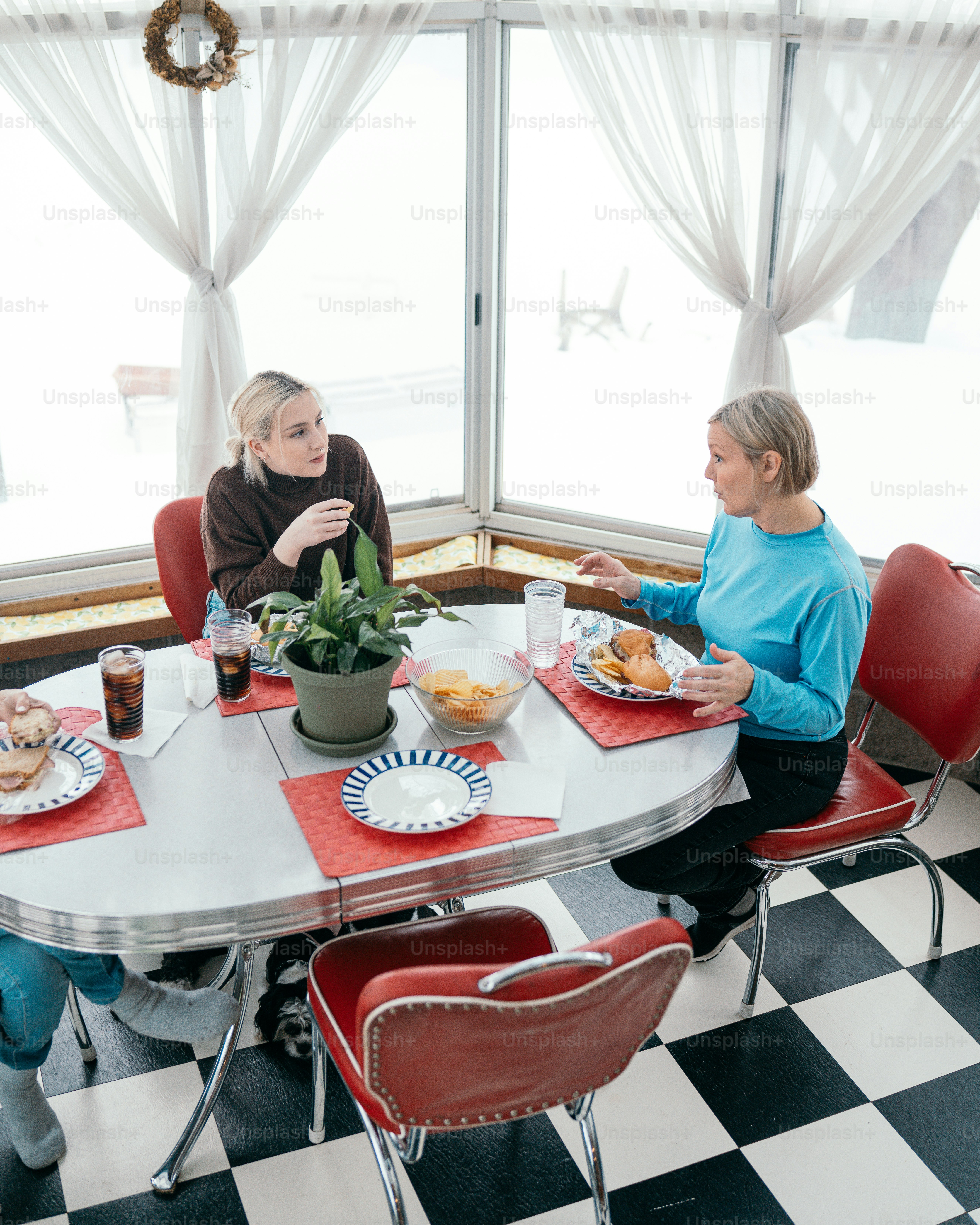A group of people sitting around a table eating food photo – Eating out ...