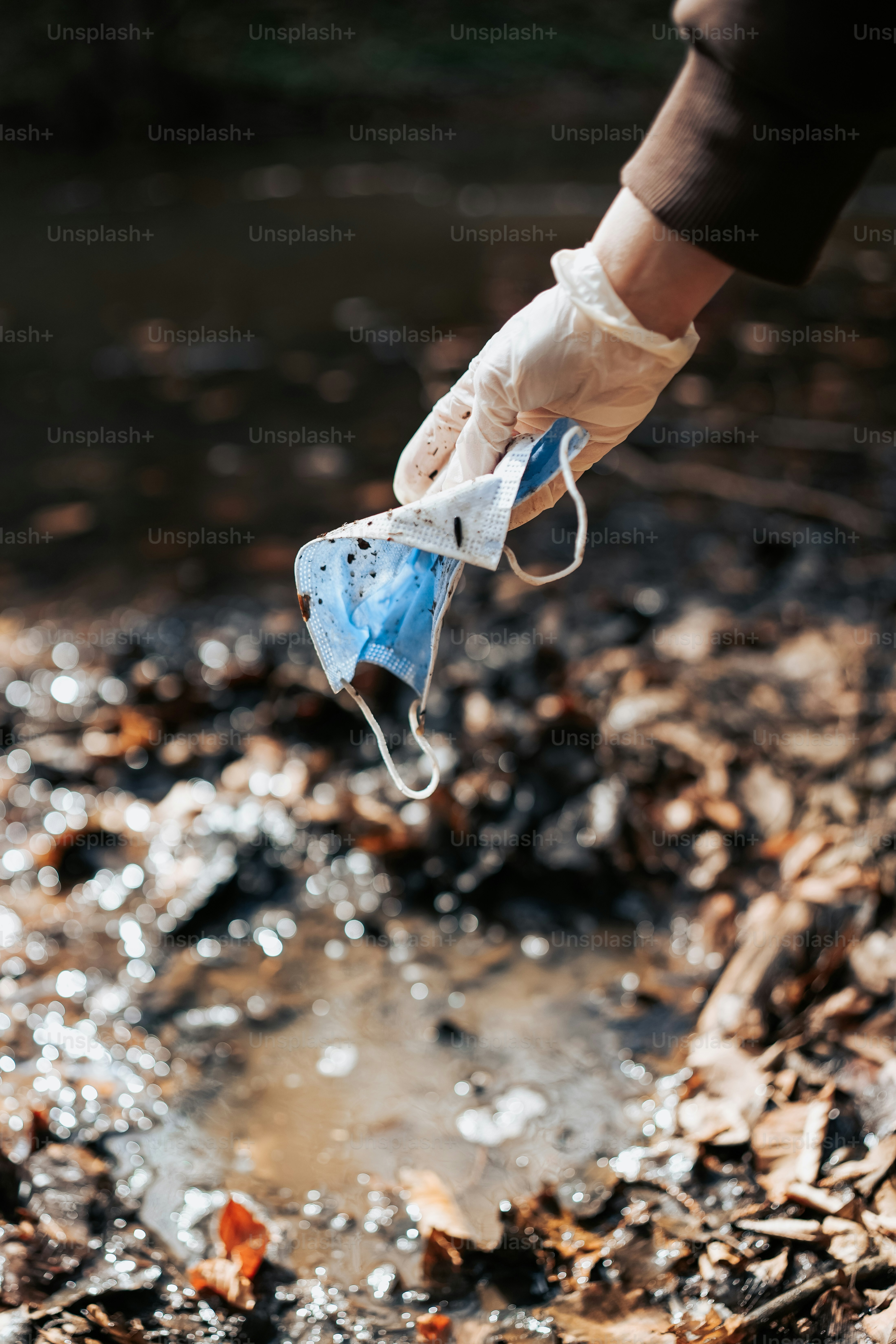 Una mano enguantada sosteniendo una máscara azul y blanca foto – Imagen ...