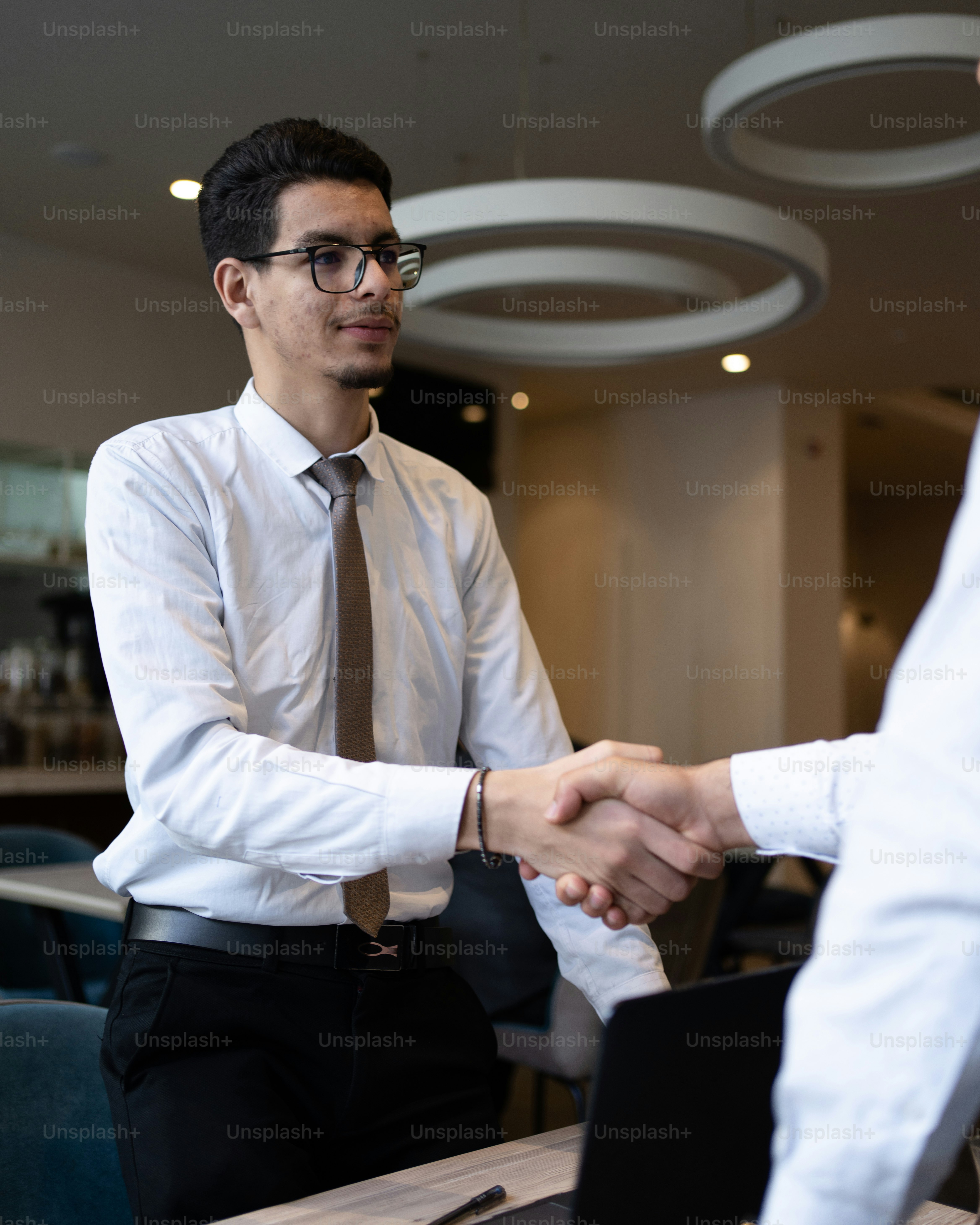 Zwei Männer schütteln sich die Hände vor einem Laptop Foto – Bild zum ...
