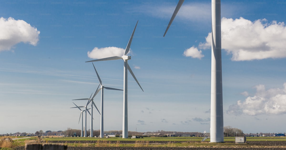 Eine Reihe Von Windrädern Auf Einem Feld Foto Bild Zum Thema Windpark