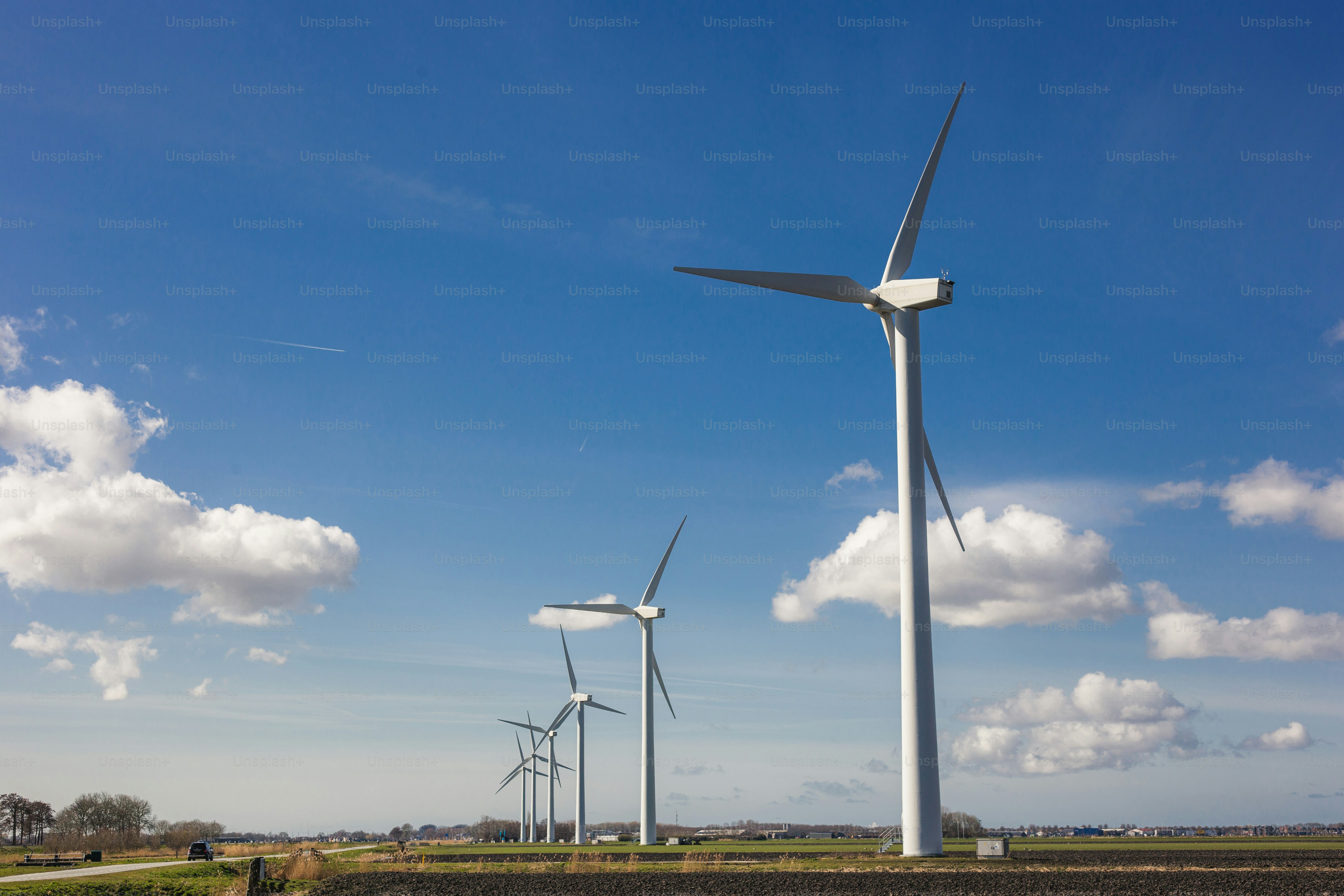 A row of wind turbines in a field photo – Wind energy Image on Unsplash