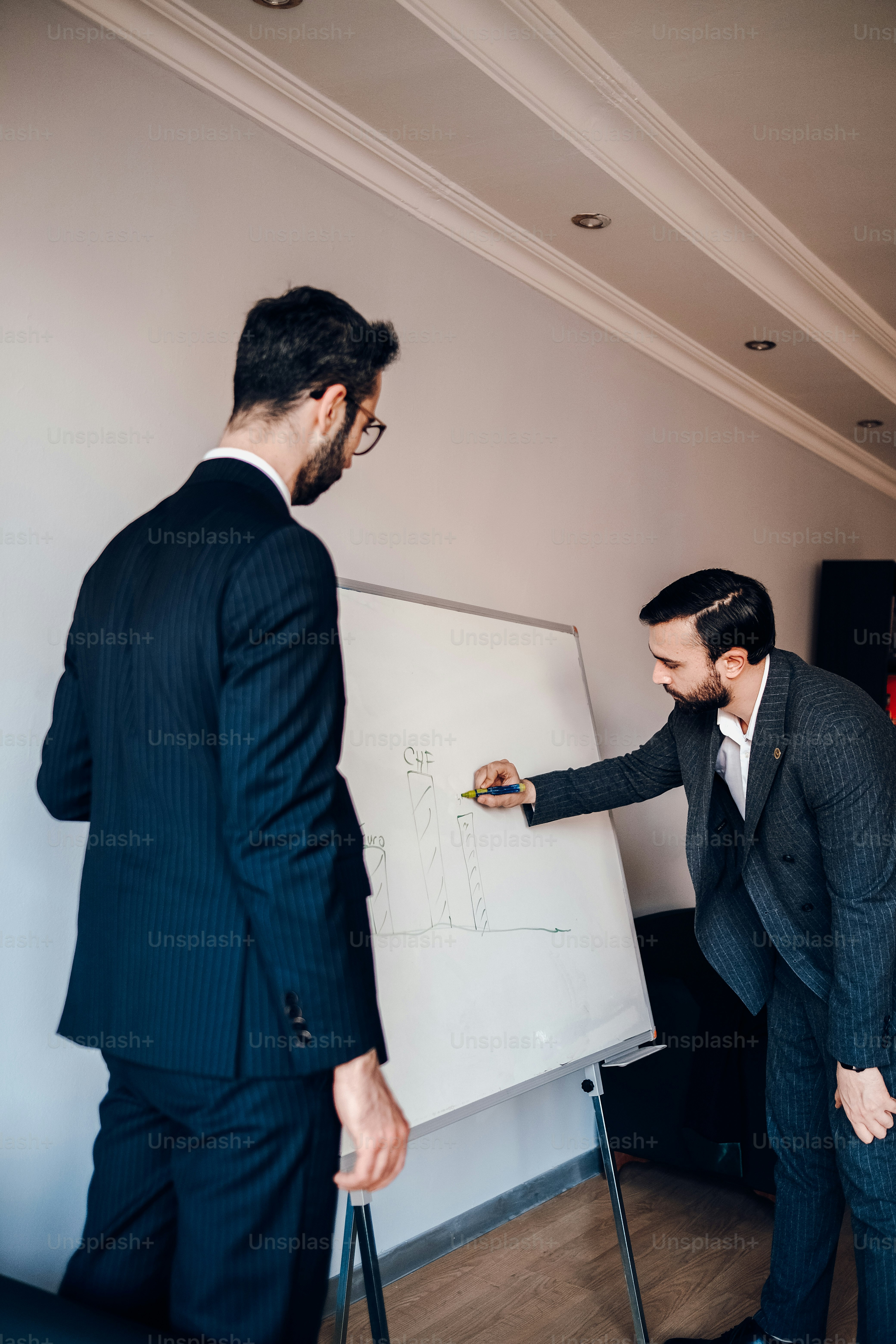 Zwei Männer in Anzügen stehen vor einer weißen Tafel Foto – Bild zum ...