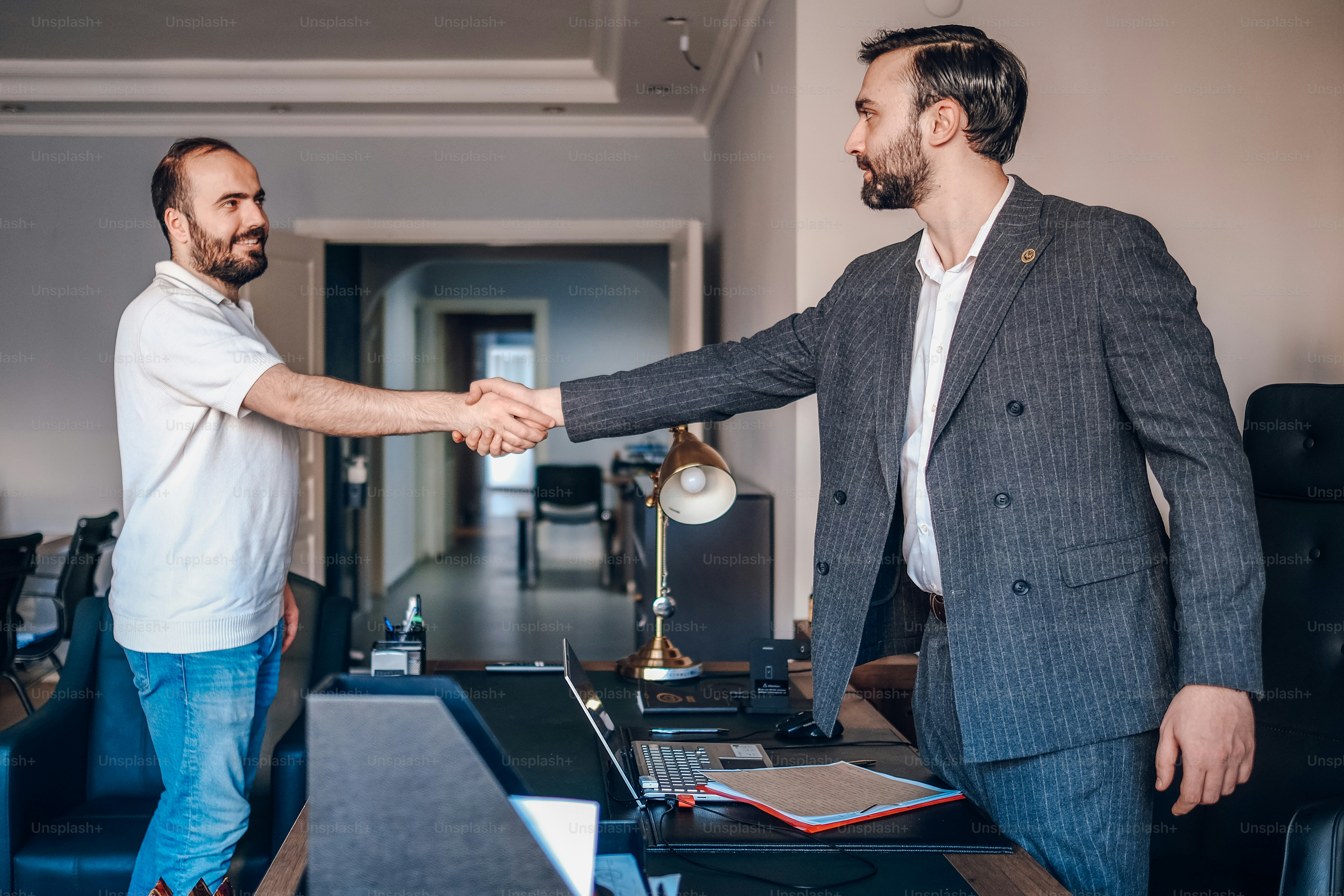 Two men shaking hands in an office setting photo – Job interview Image ...