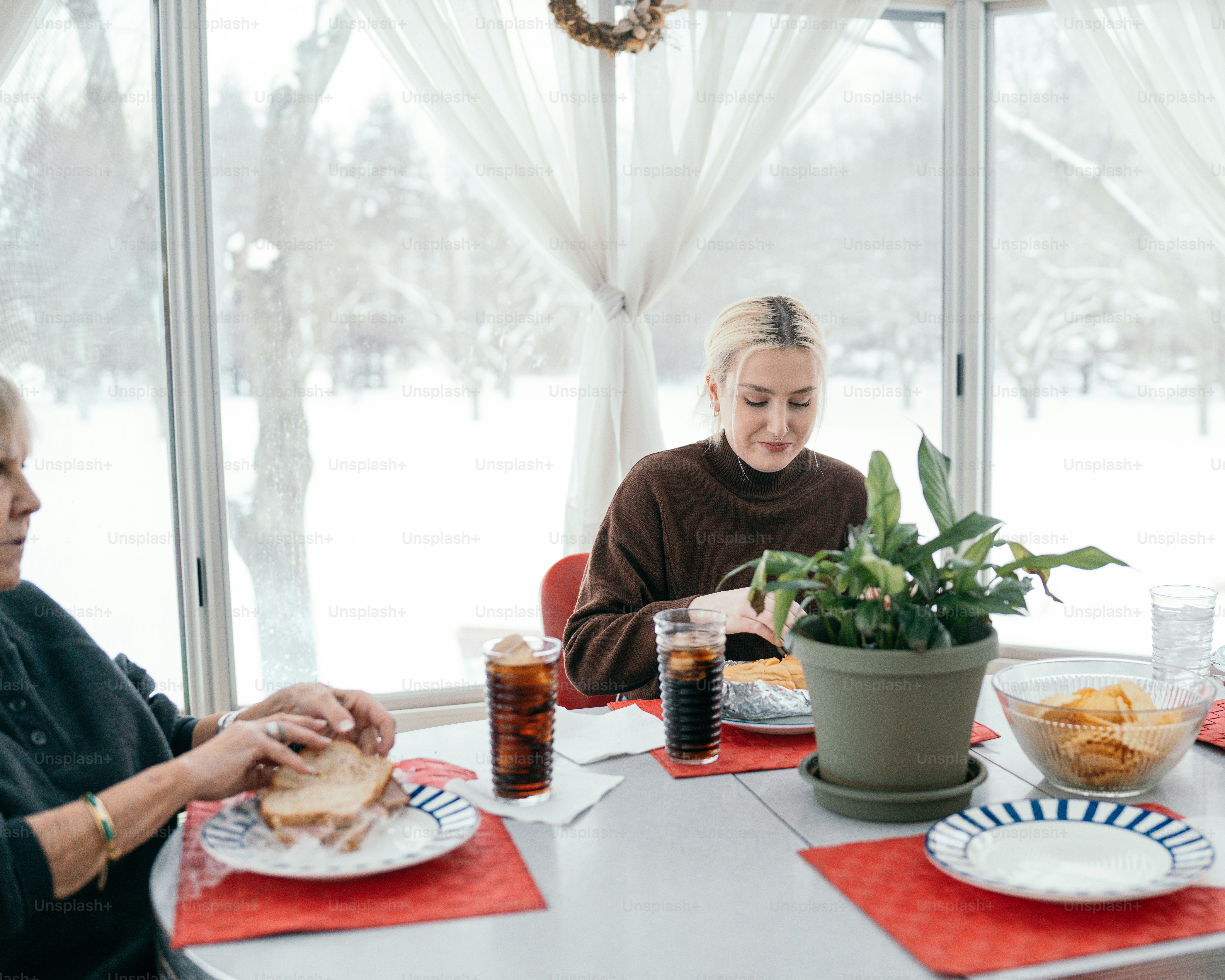A group of women sitting around a table eating food photo – Dining ...