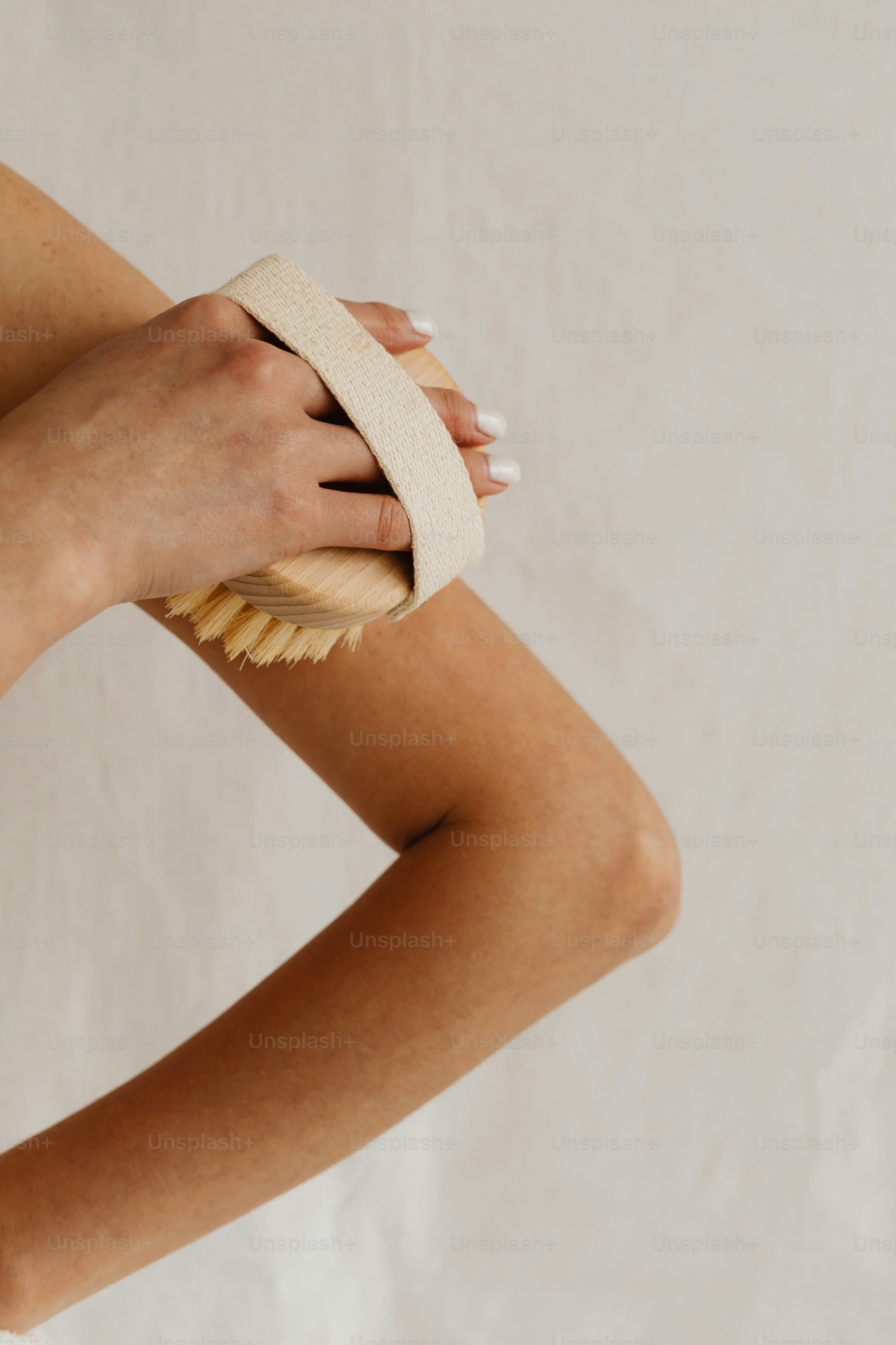 A woman holding a hair brush in her hand photo – Body brushing Image on ...
