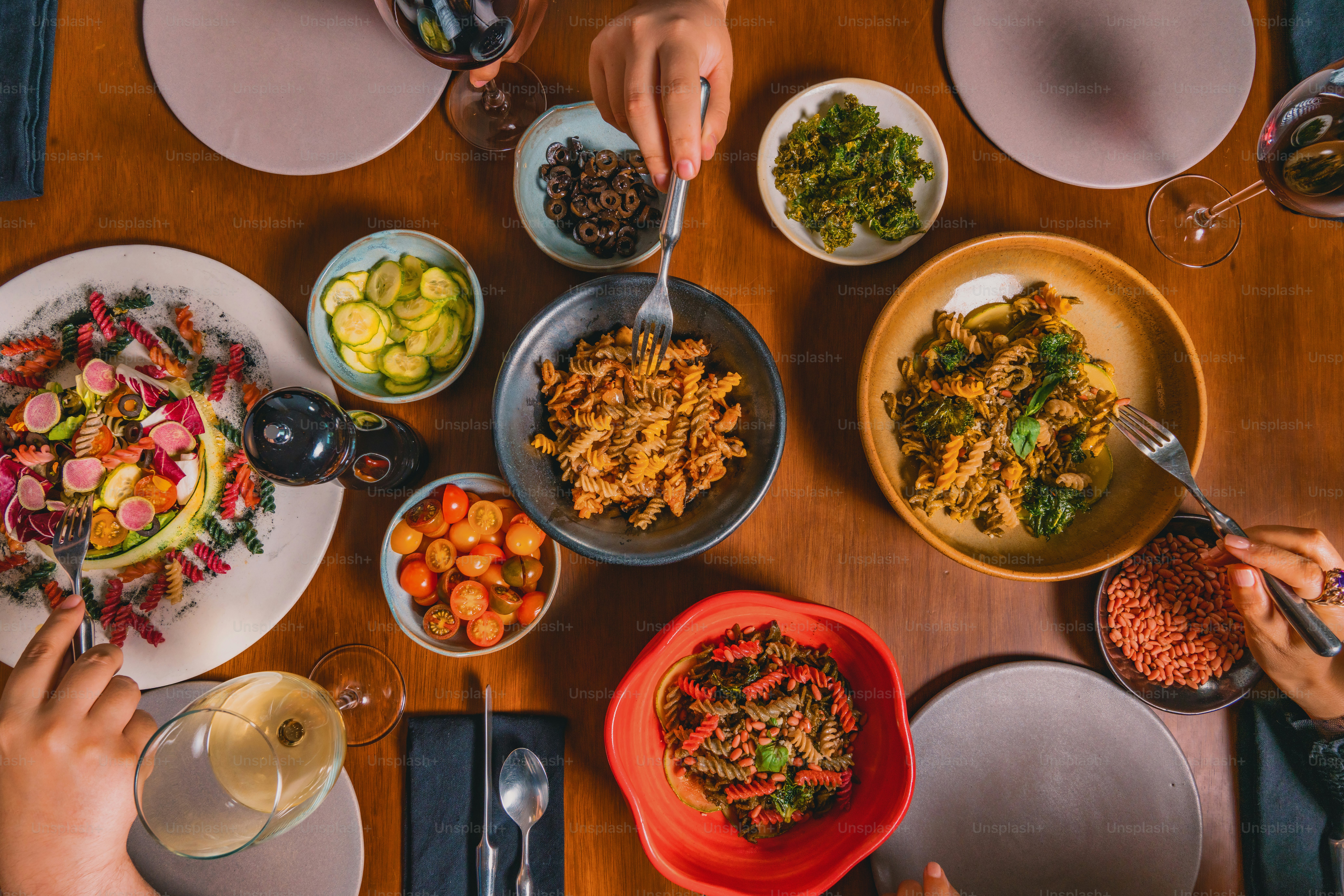 Un grupo de personas sentadas en una mesa con platos de comida foto ...