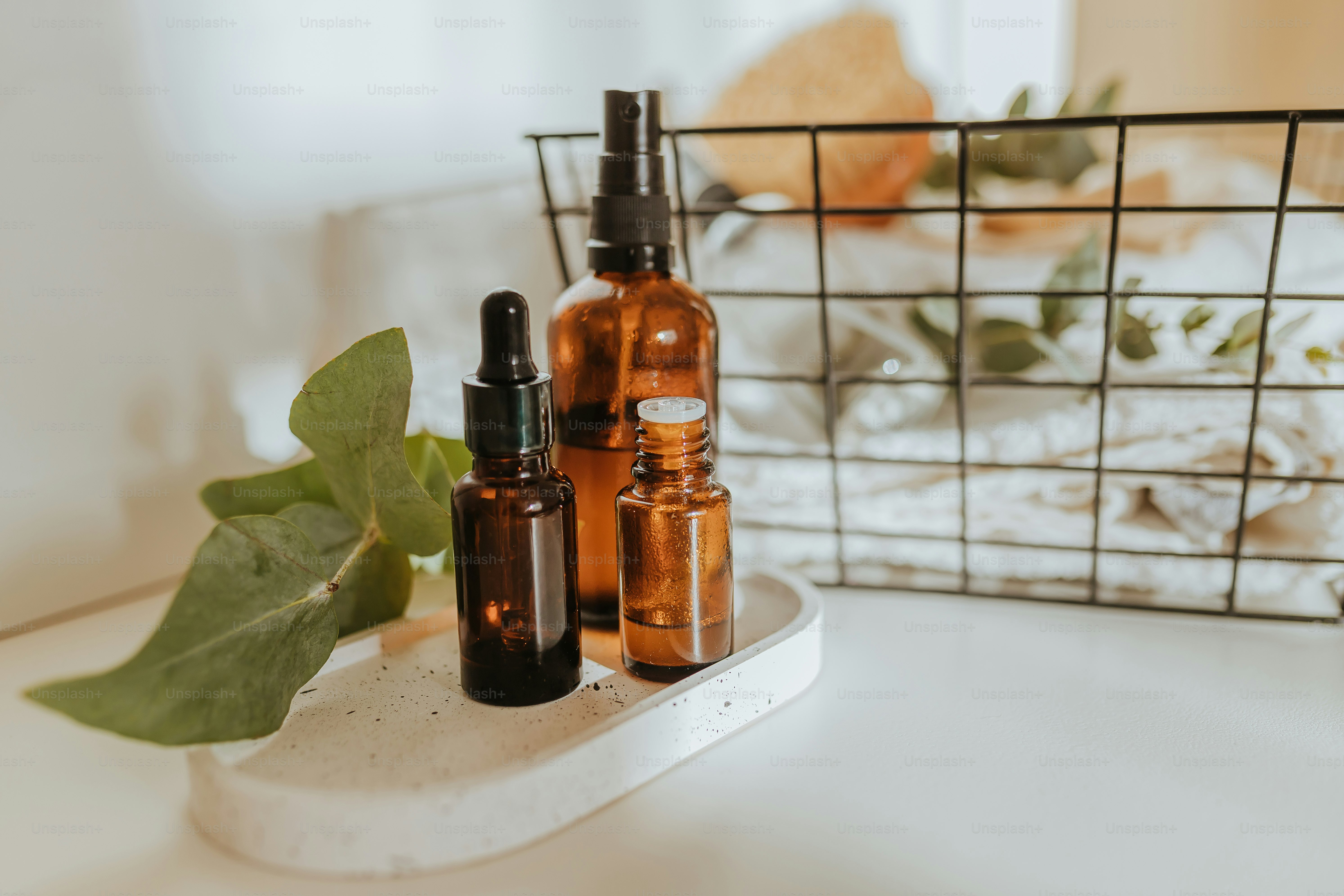 Three bottles of essential oils sitting on a counter photo – Skincare ...
