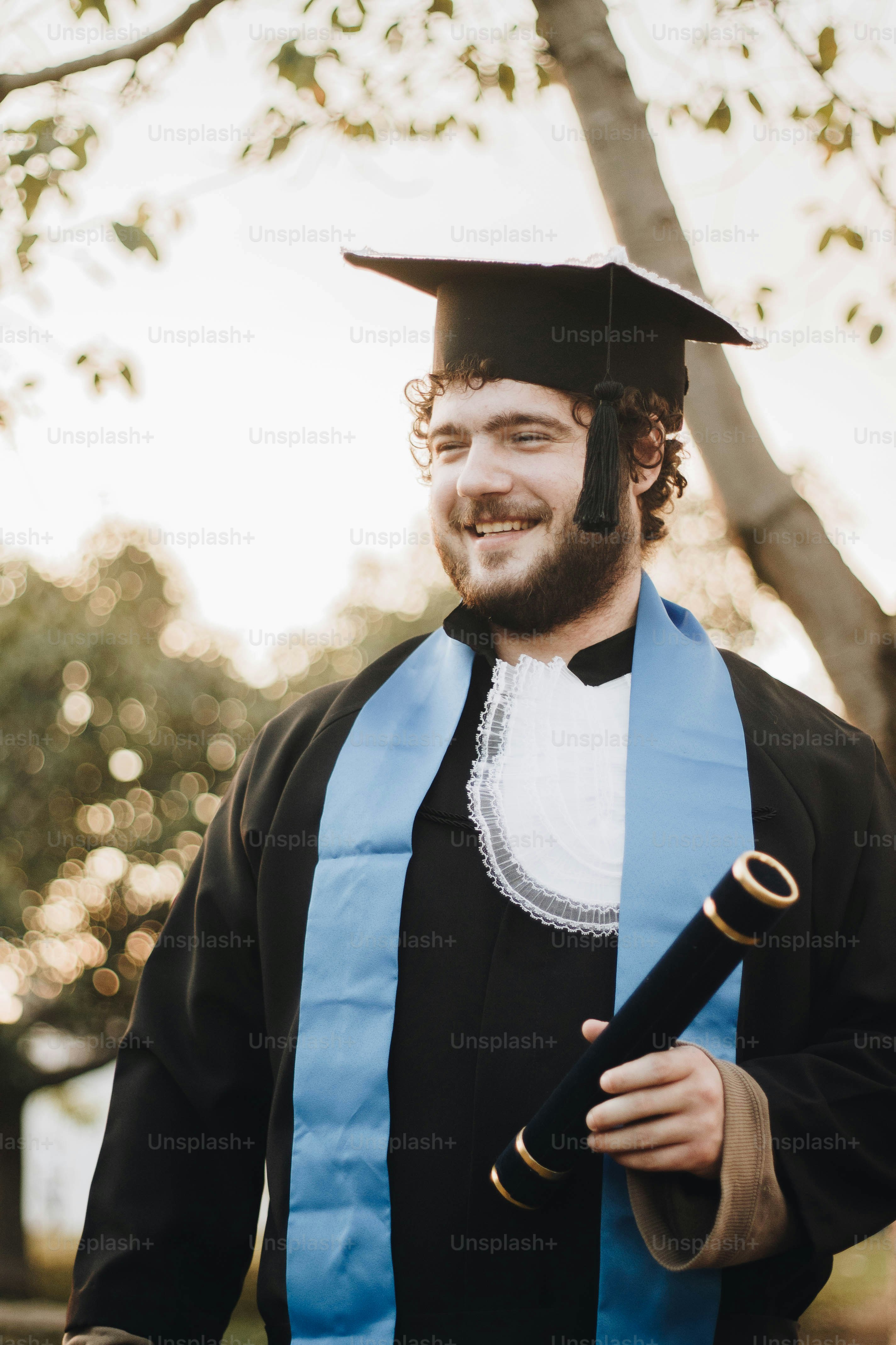 A man in a cap and gown holding a diploma photo – Degree Image on Unsplash