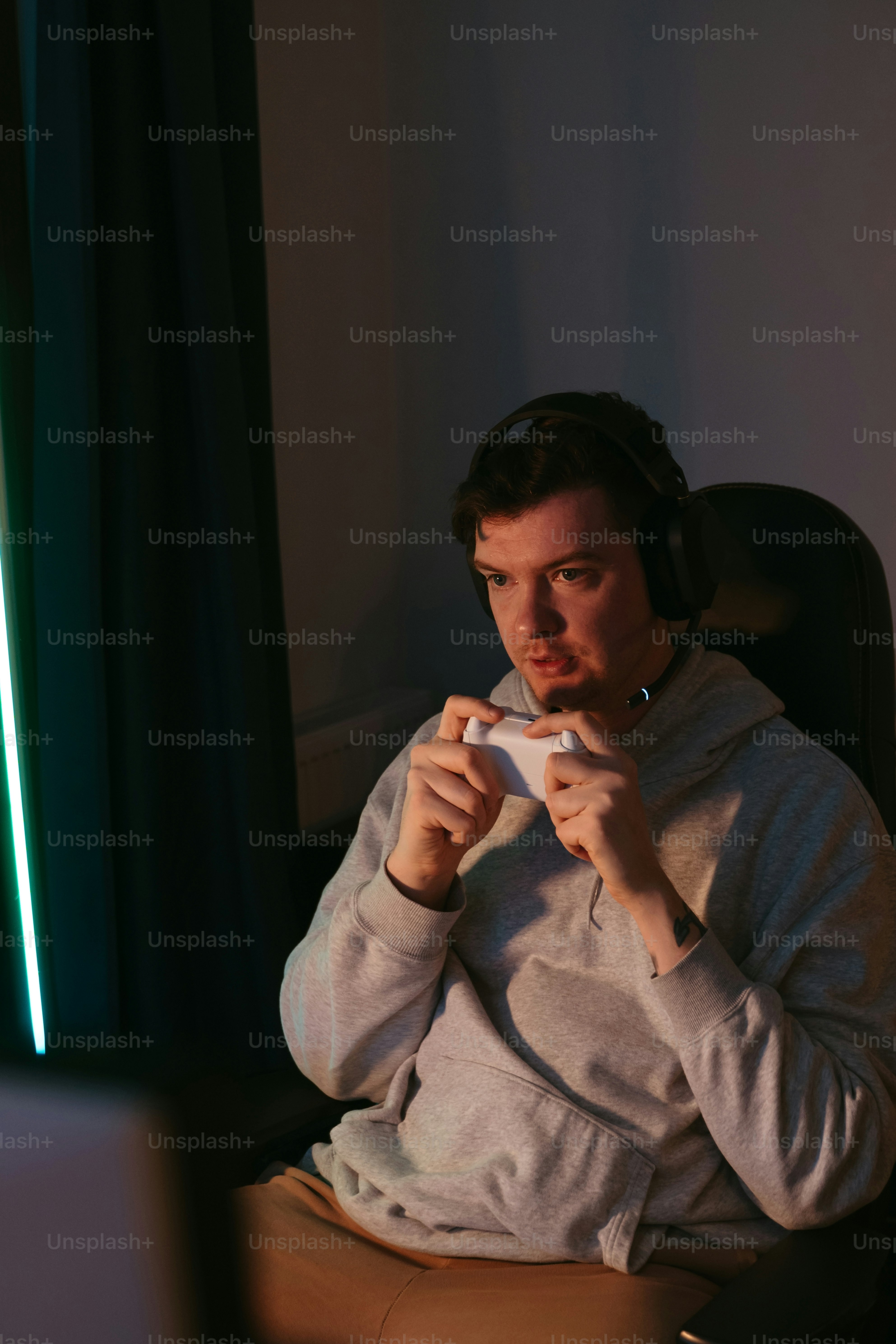 Una persona sentada en una silla con un control remoto foto – Imagen de ...