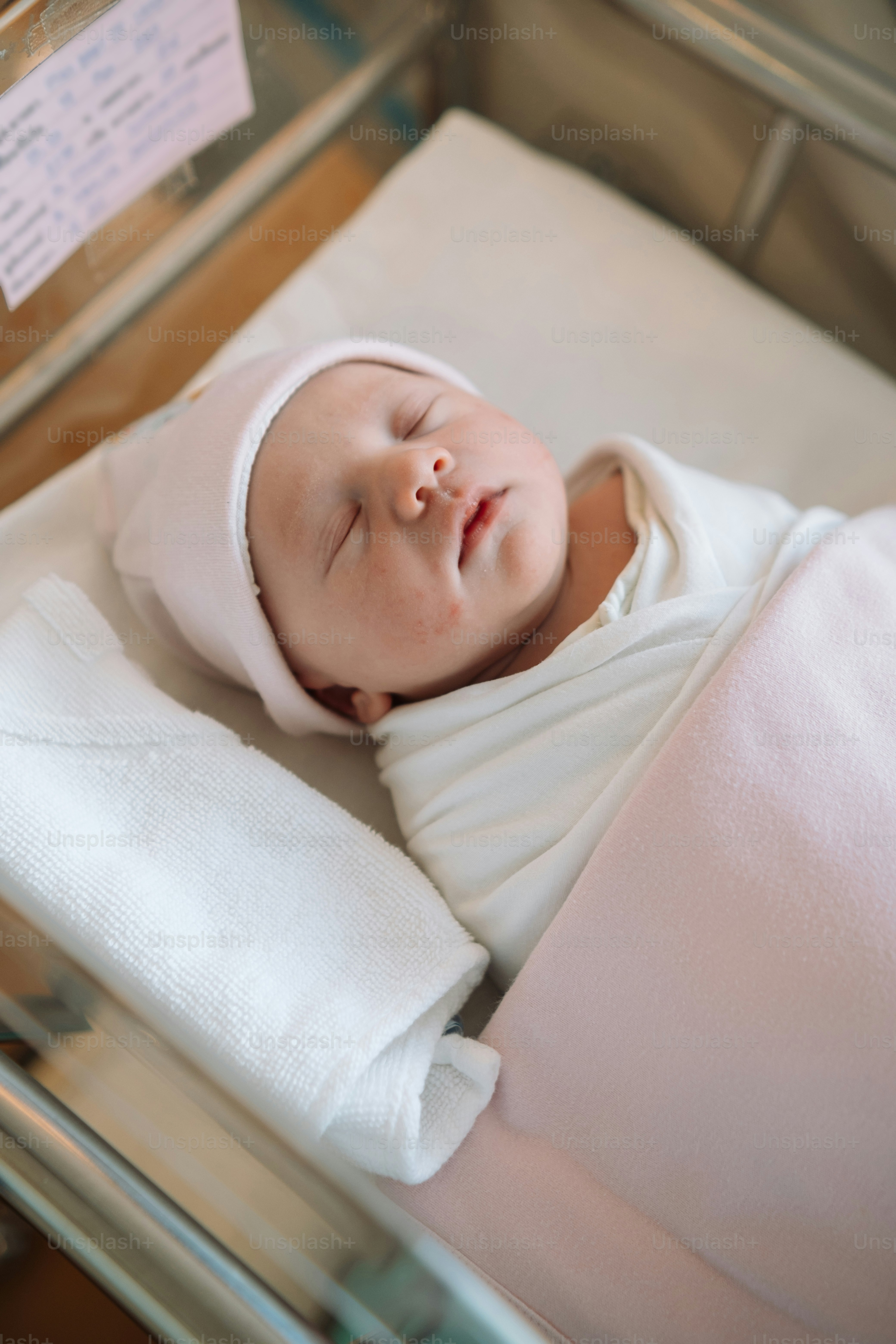 A baby is sleeping in a glass crib photo – Baby Image on Unsplash