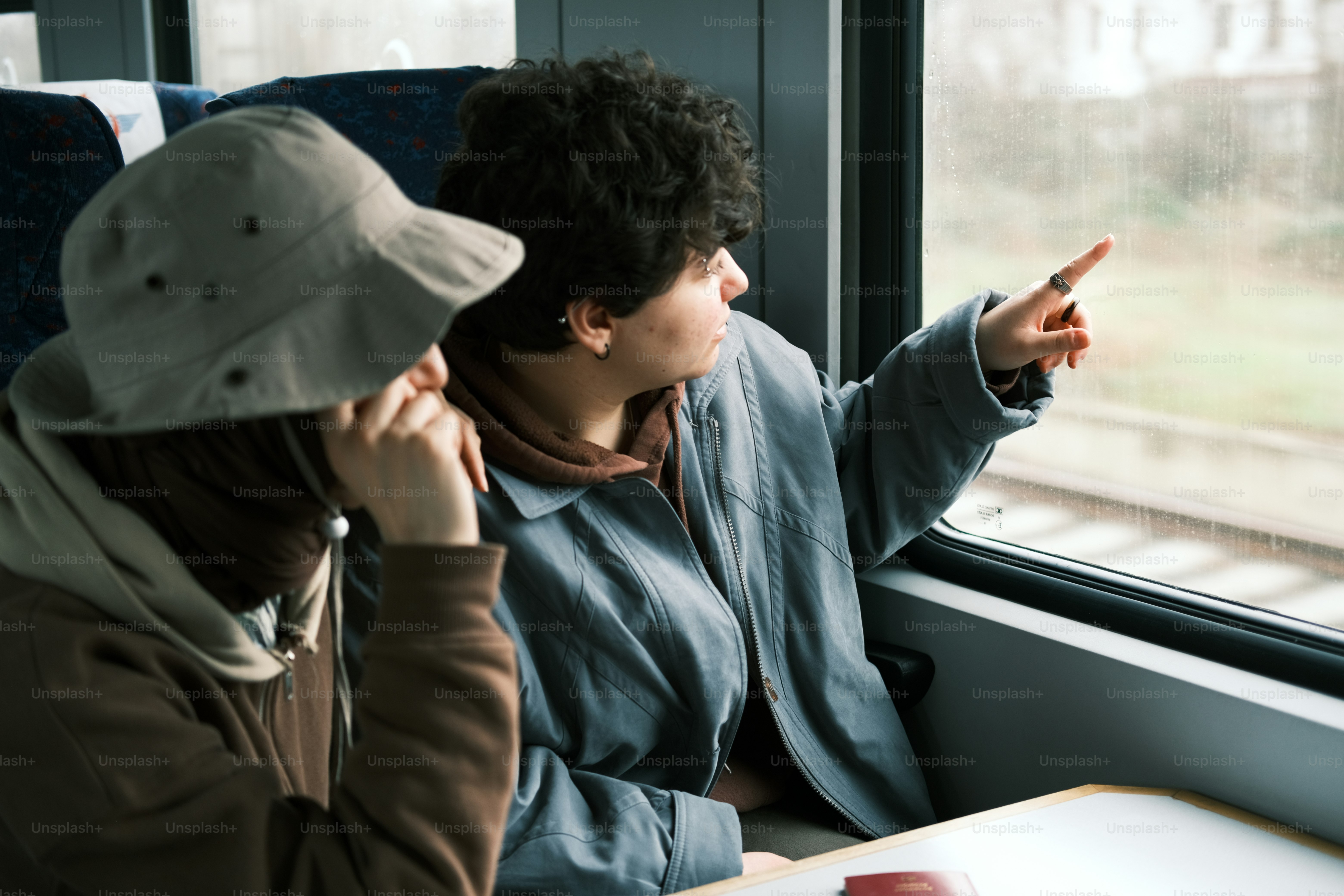A couple of people sitting next to a window photo – Europe travel Image ...
