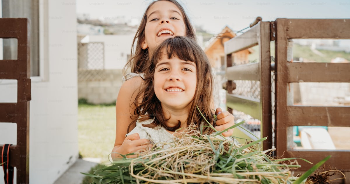 Deux Jeunes Filles Debout à Côté Dun Tas De Foin Photo Des Enfants