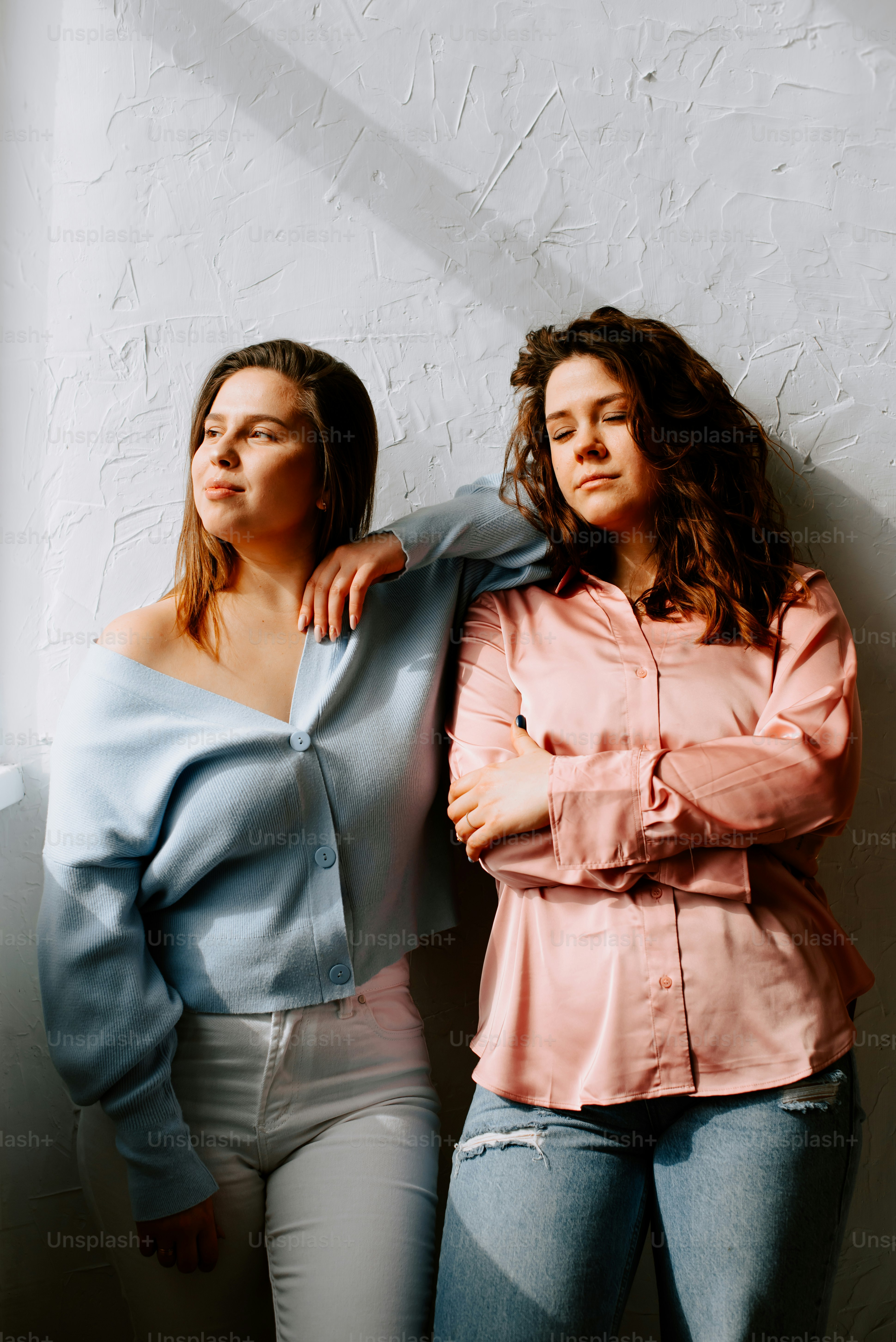 Foto Duas mulheres em pé uma ao lado da outra na frente de uma parede ...