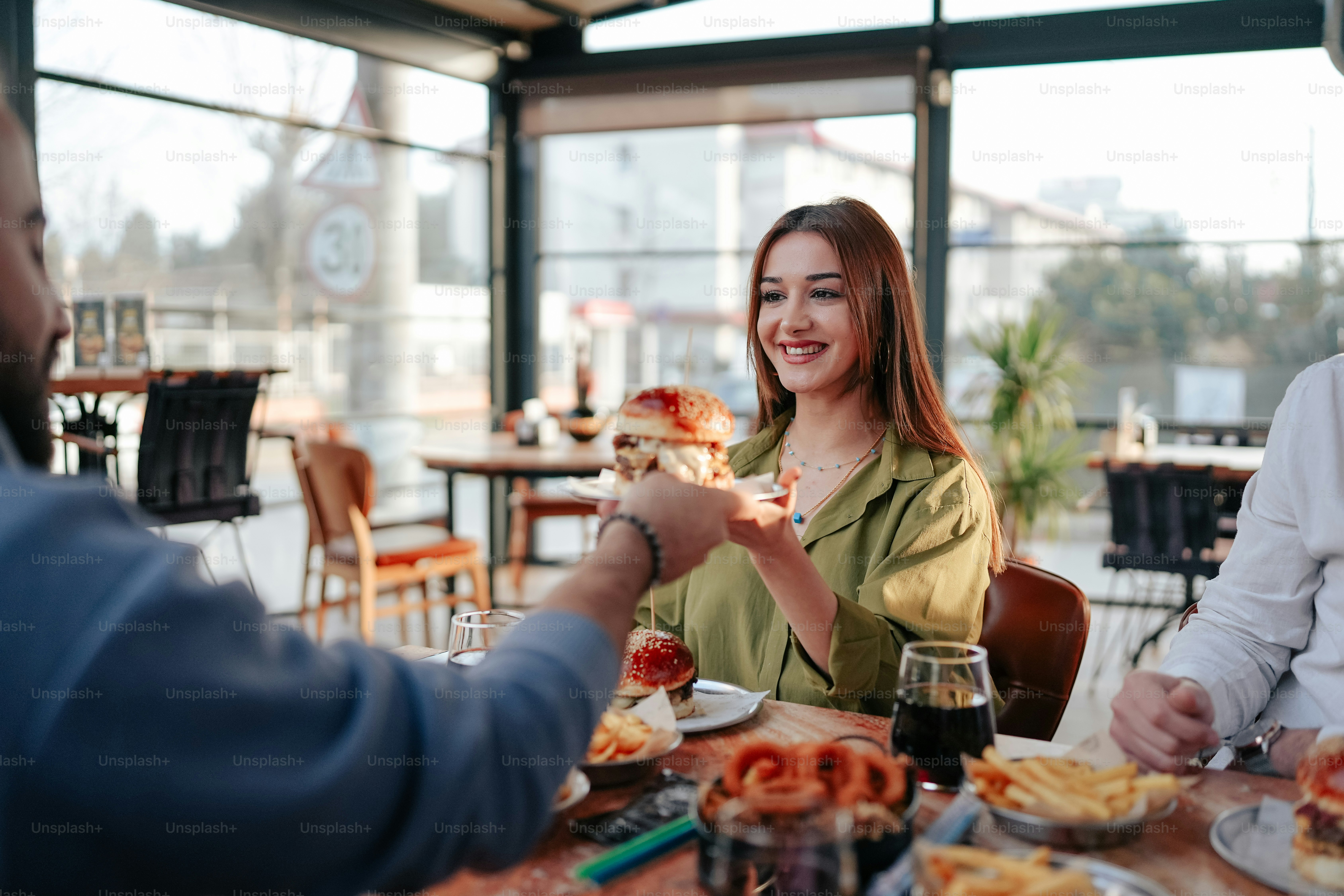 A man and a woman sitting at a table eating pizza photo – Eating out ...
