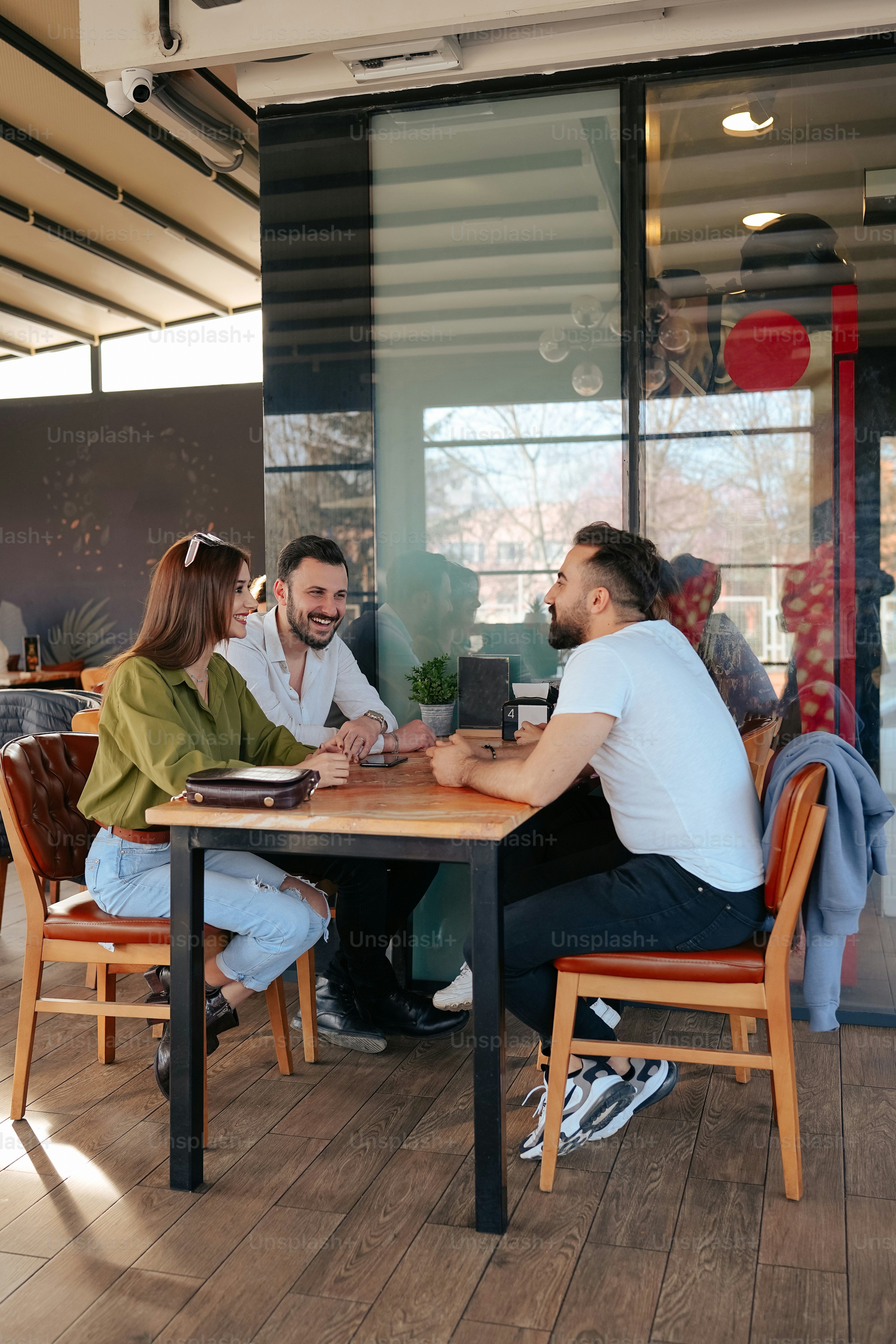 Un groupe de personnes assises autour d’une table en bois photo – Homme ...