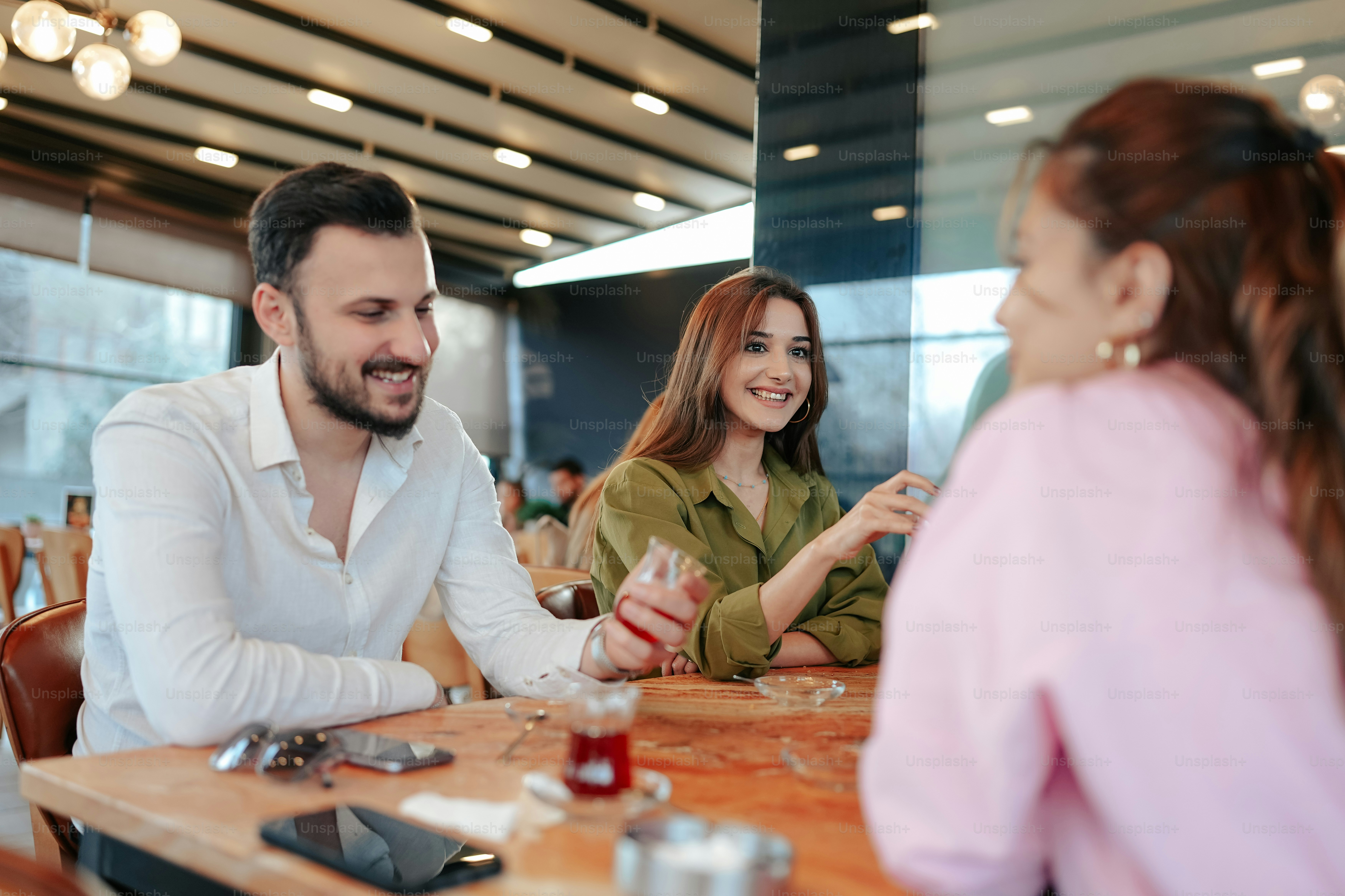 Un groupe de personnes assises à une table en train de manger une pizza ...