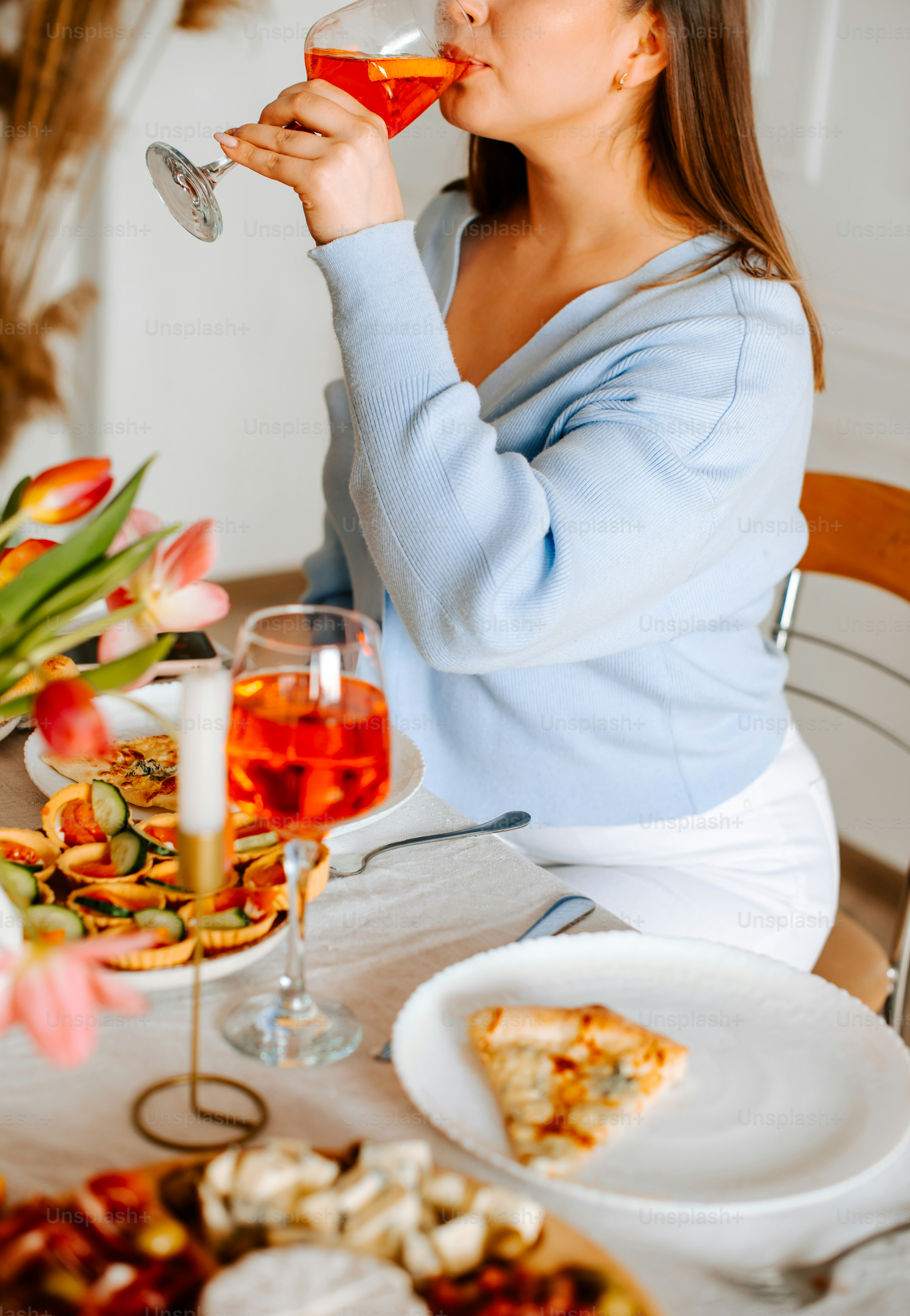 A woman sitting at a table drinking a glass of wine photo – Food Image on Unsplash