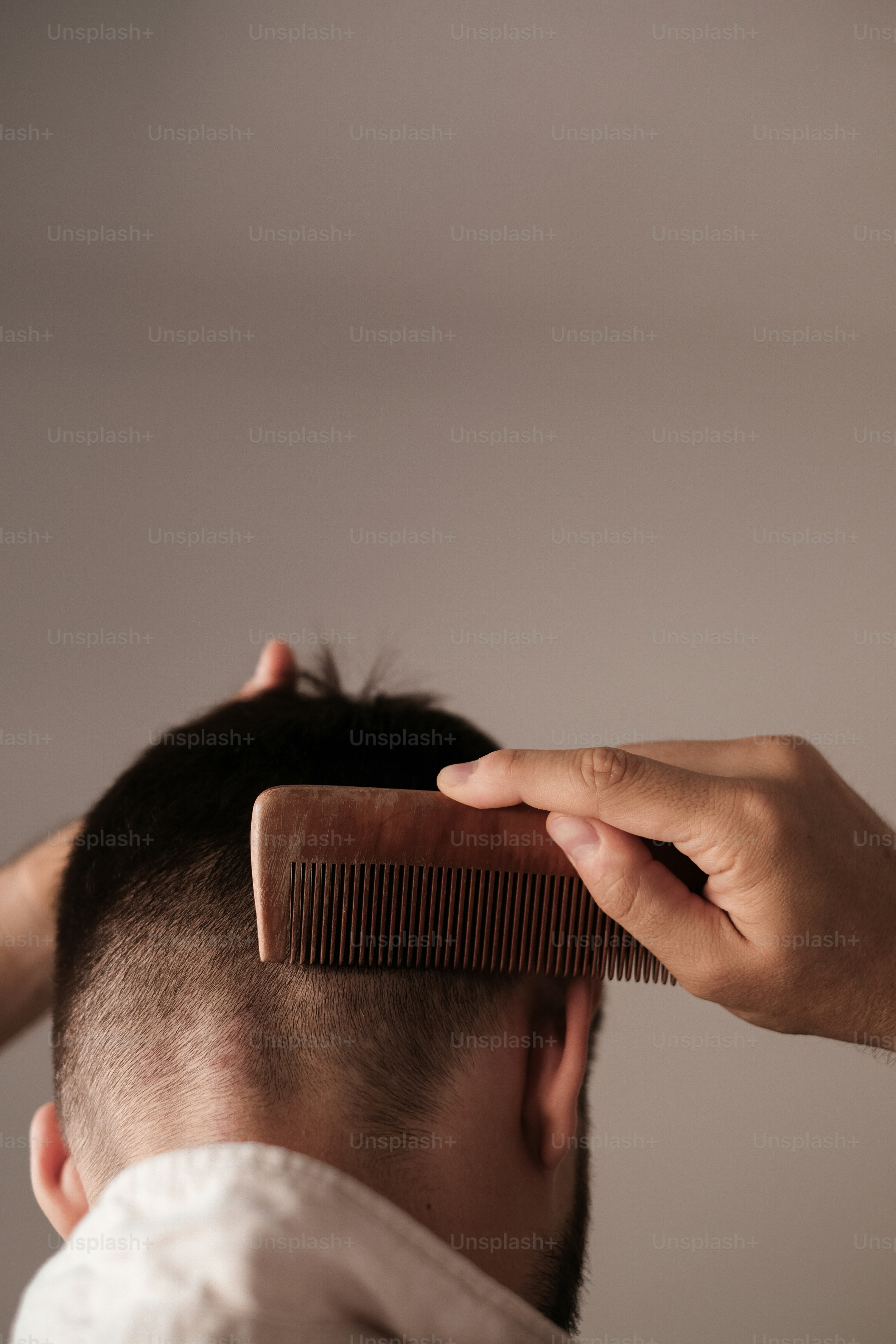 A man is combing his hair with a comb photo – Haircut Image on Unsplash