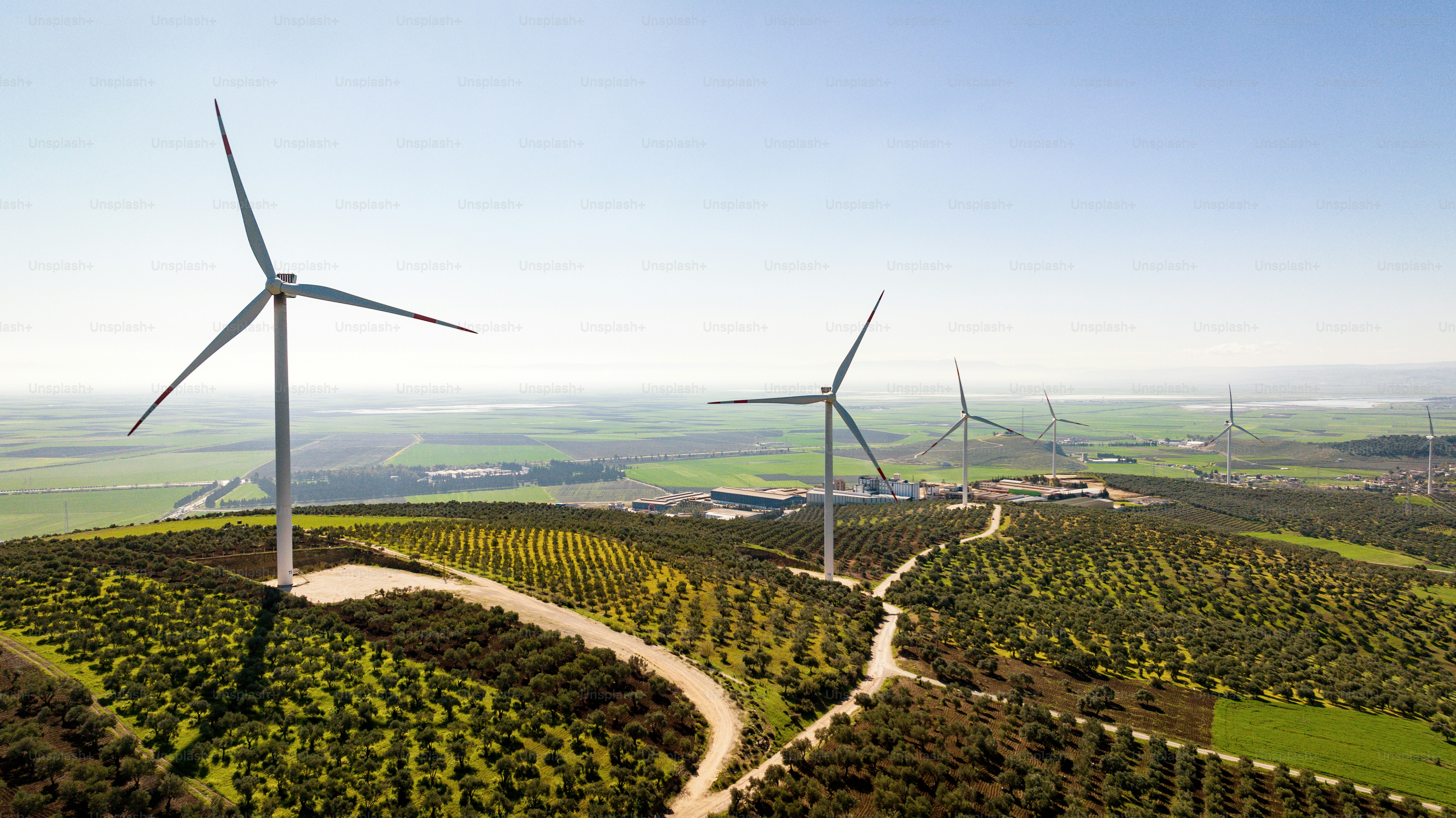 A wind farm with several windmills in the background photo – Save ...
