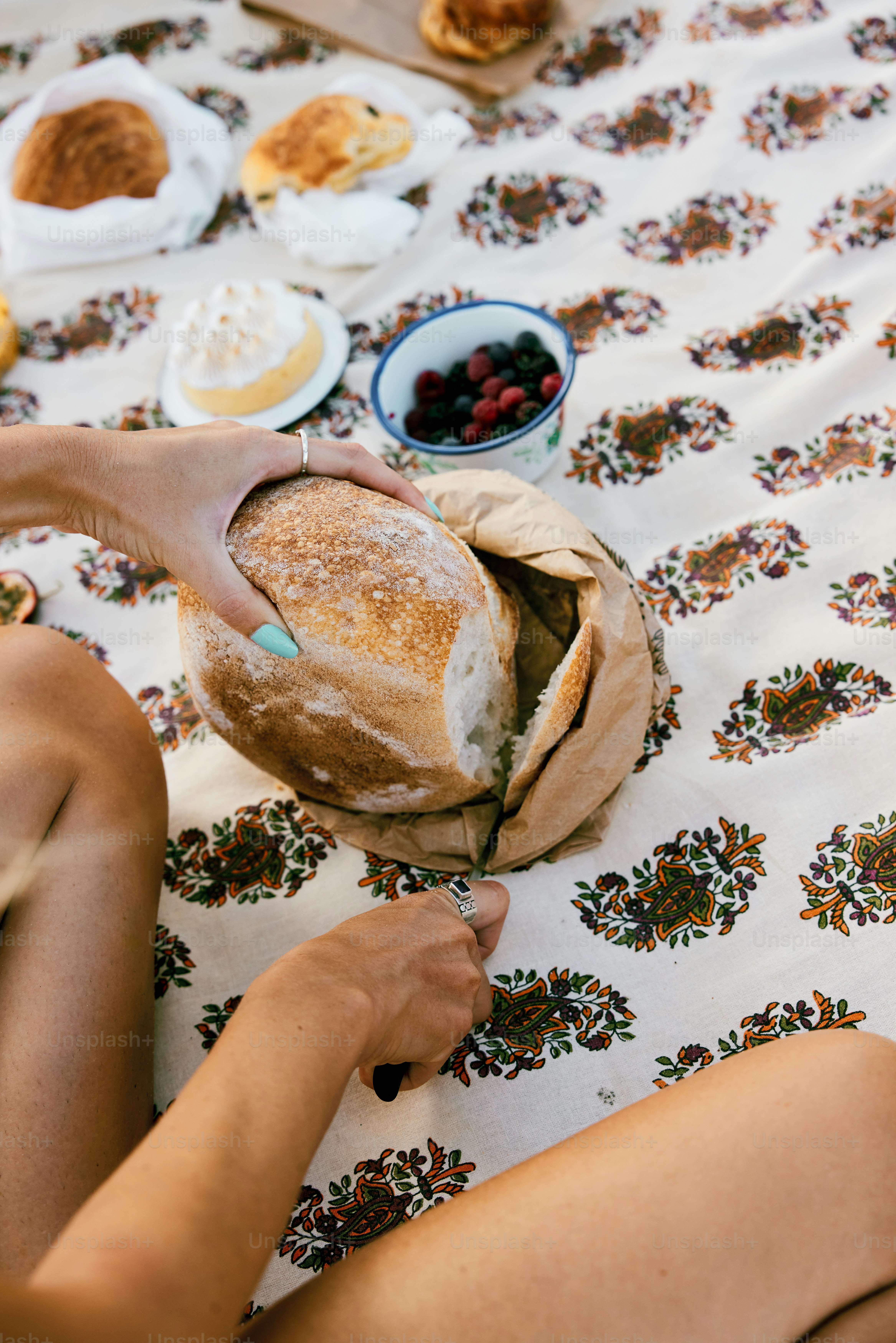 A woman sitting on a bed holding a bagel photo – Beach picnic Image on Unsplash