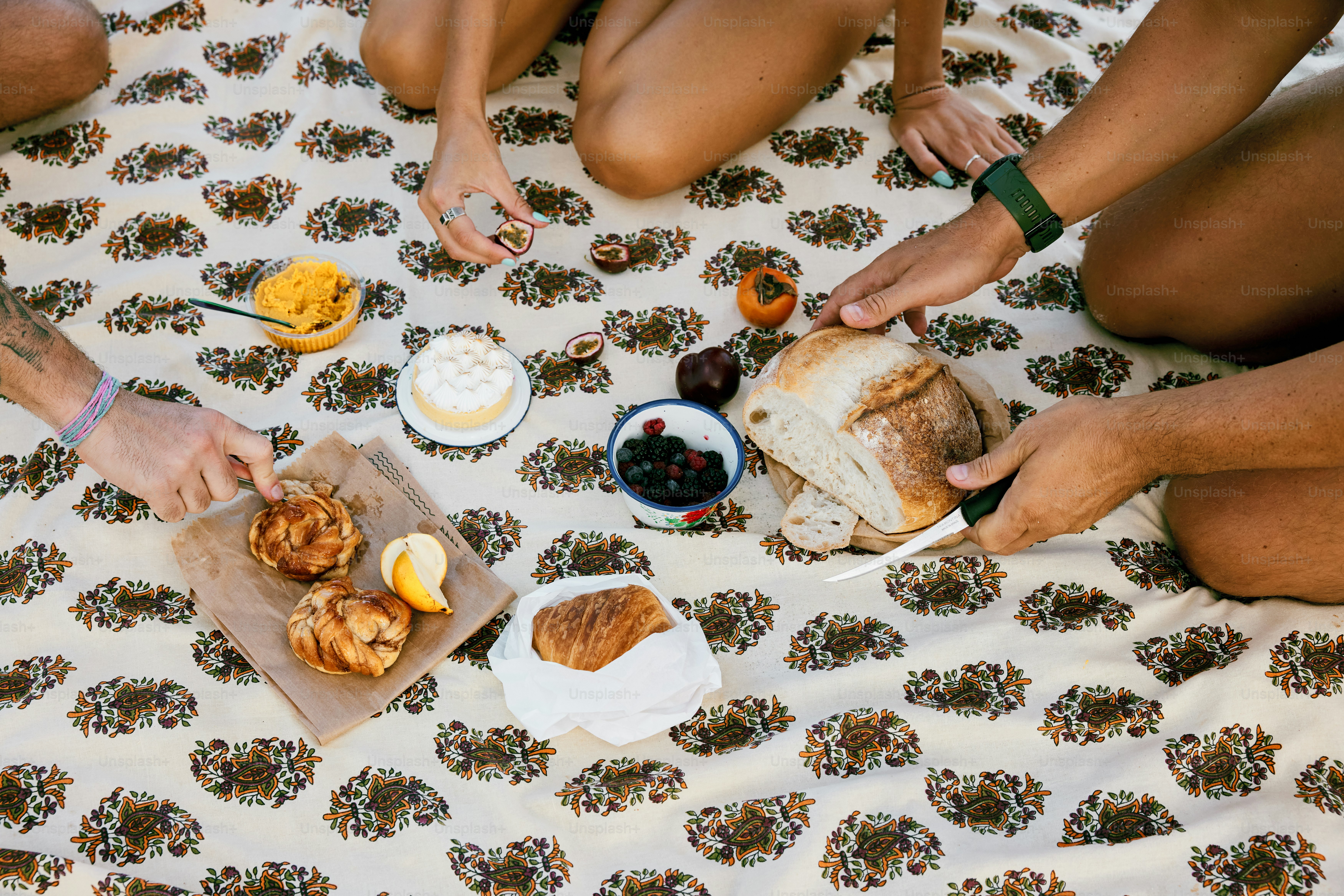 A group of people sitting on top of a bed eating food photo – Sharing ...