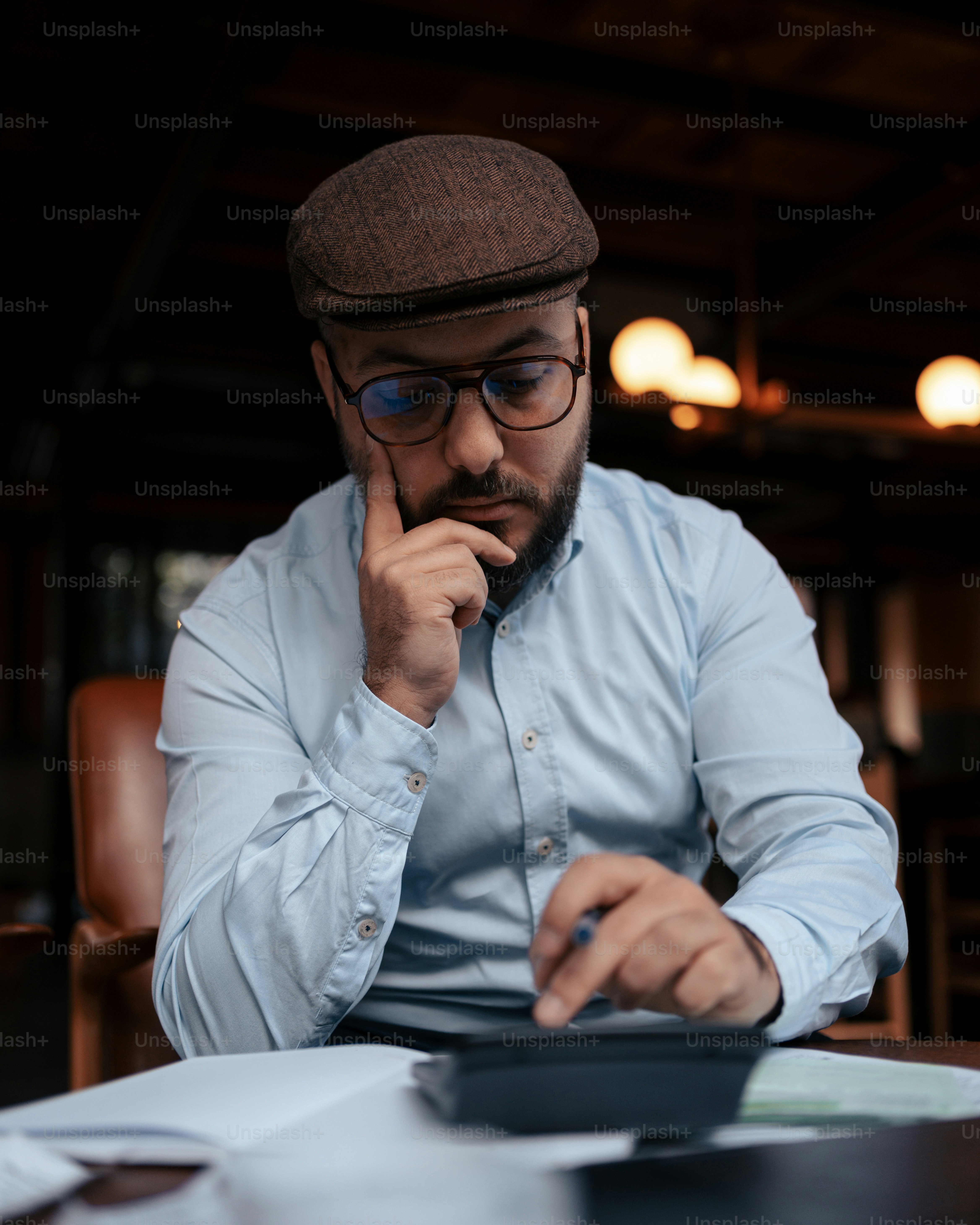 A man sitting at a table with a calculator photo – Finances Image on ...