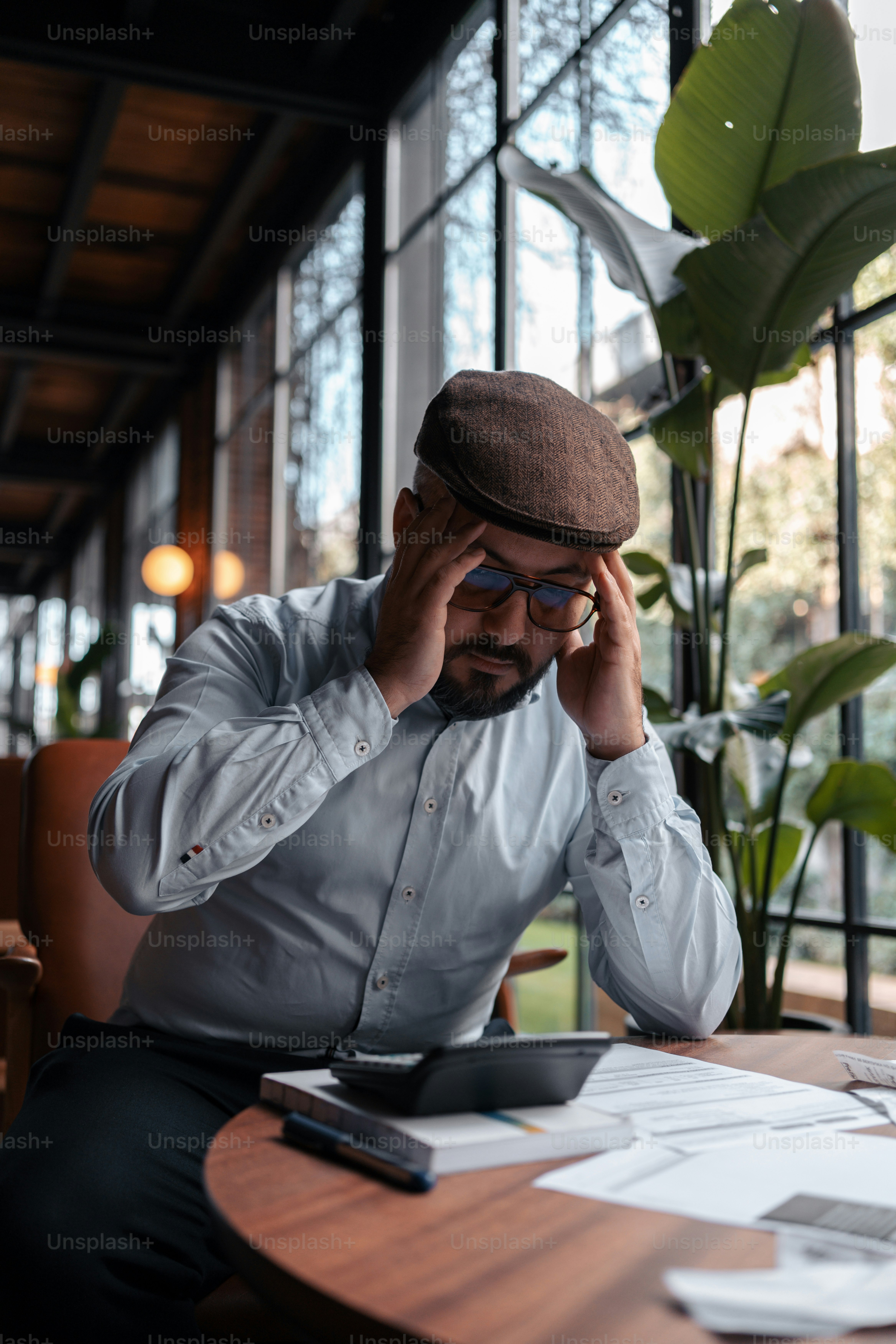 A man sitting at a table with a calculator photo – Finances Image on ...