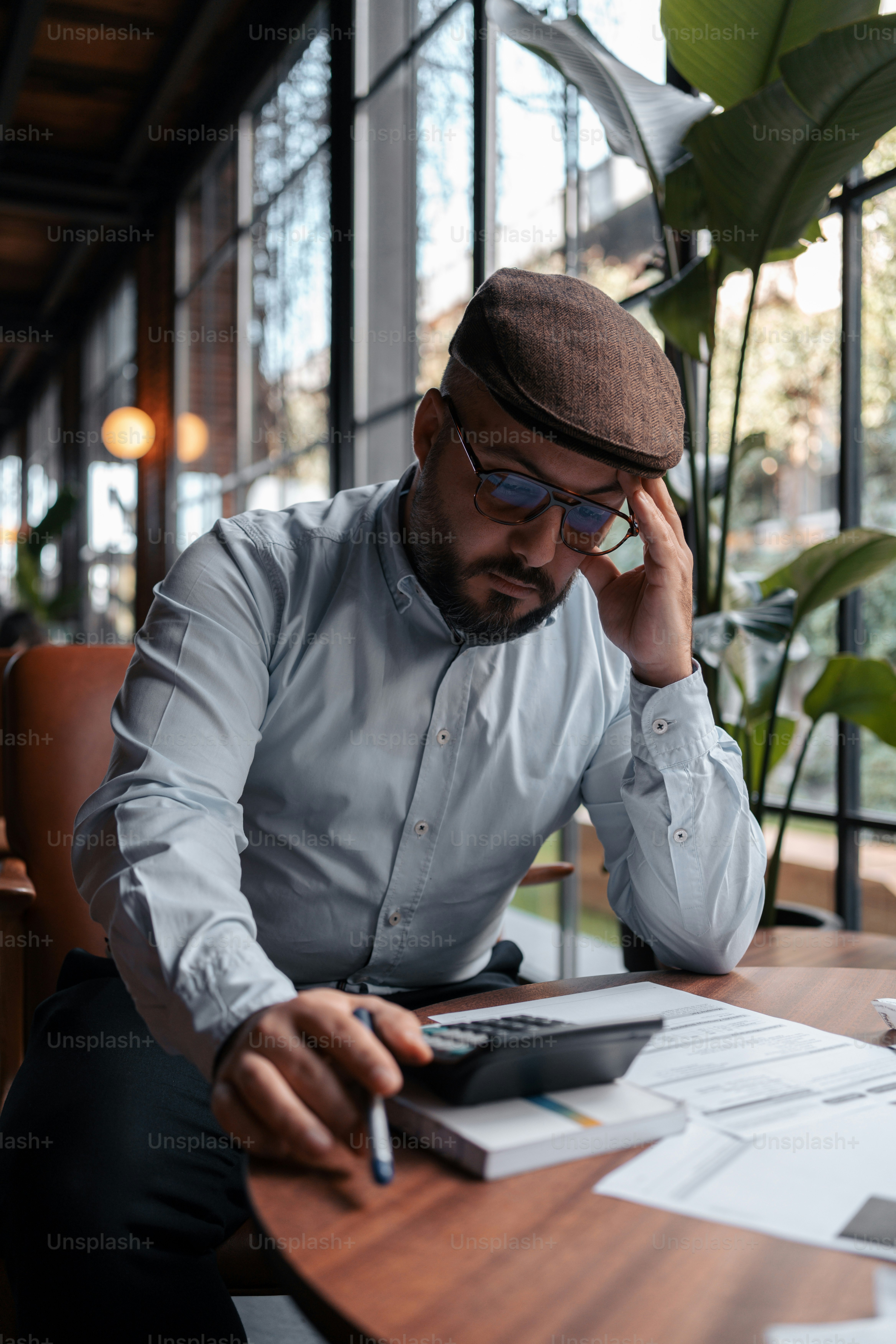 A man sitting at a table with a calculator photo – Tax Image on Unsplash