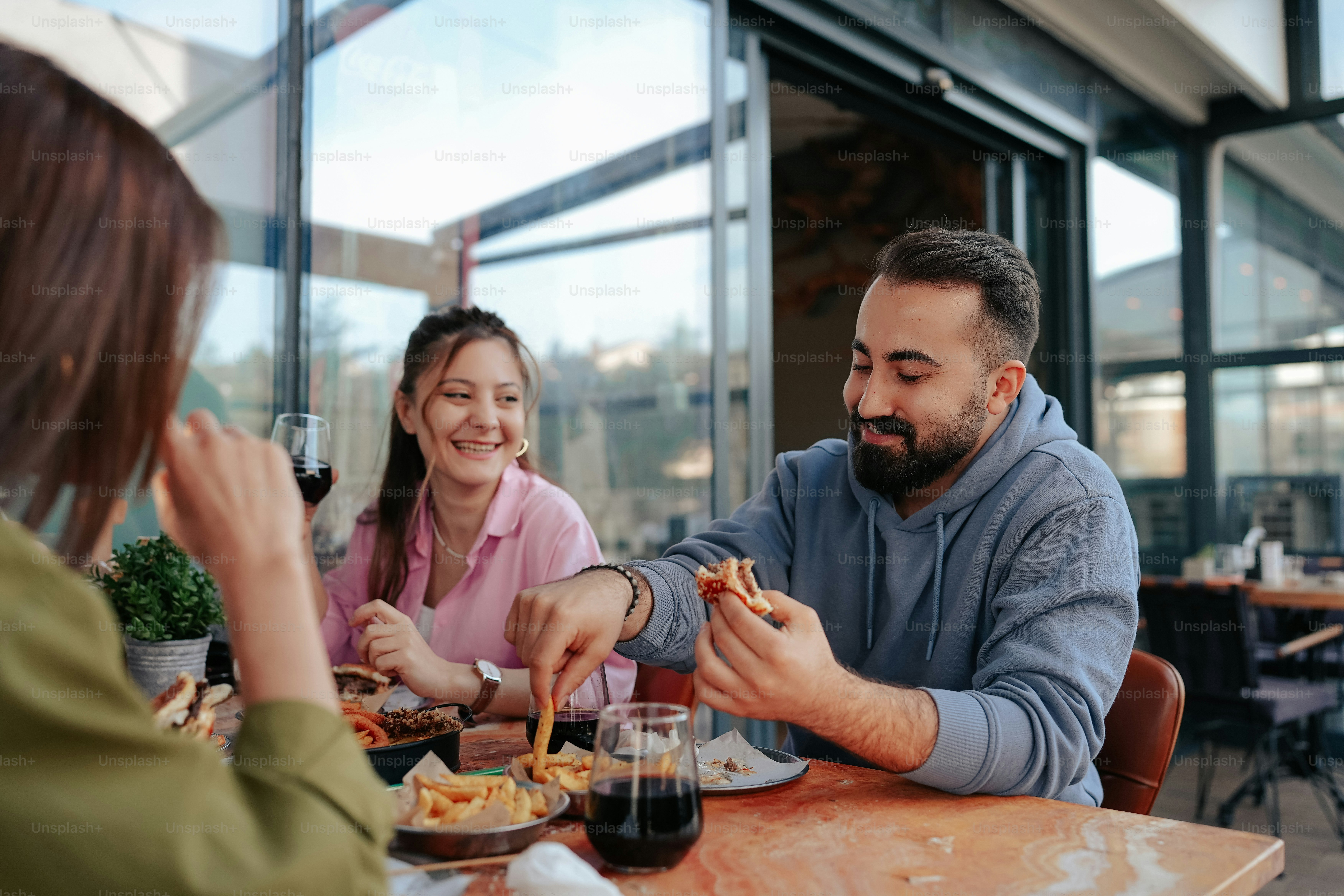 Un groupe de personnes assises autour d’une table en train de manger de ...