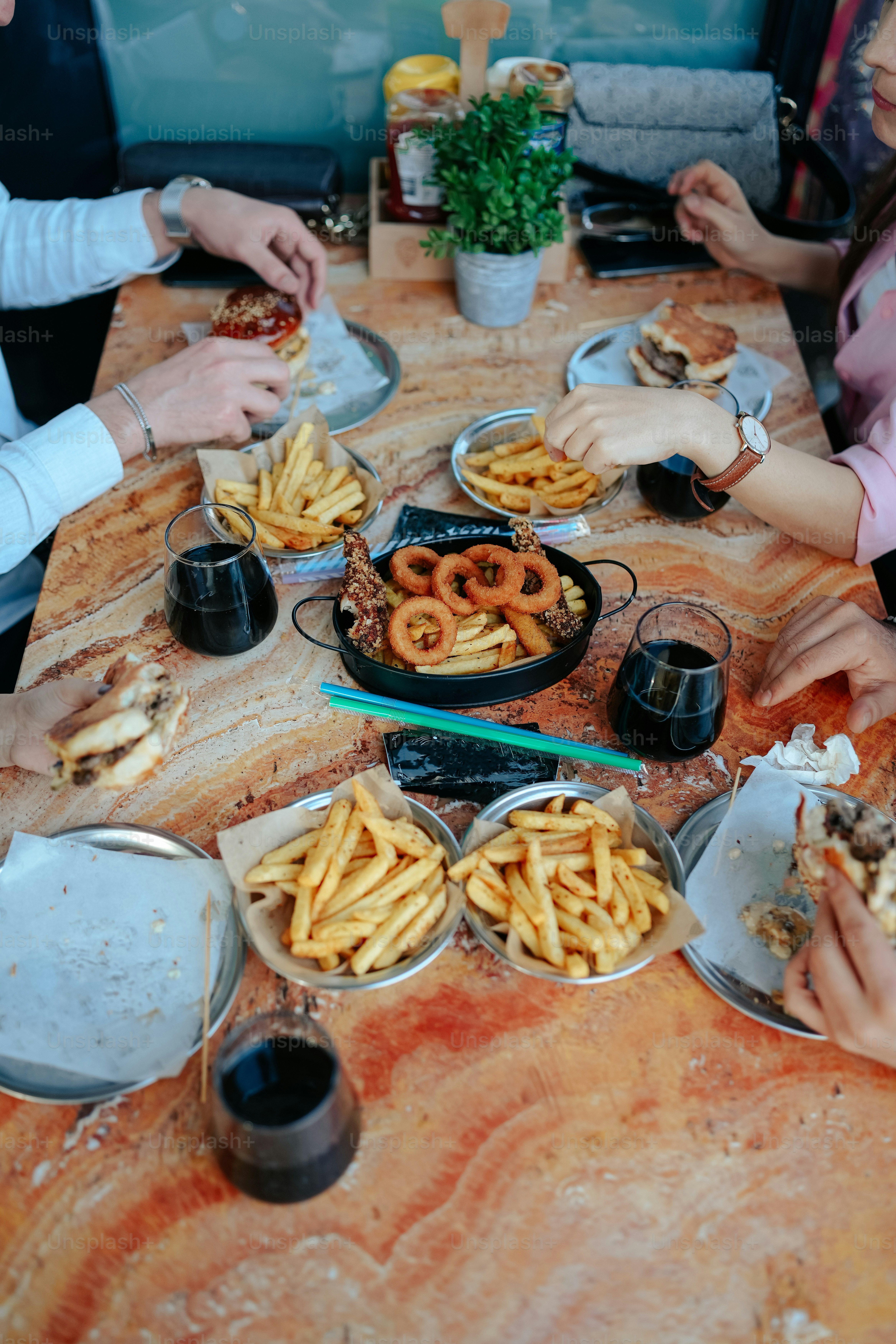 A group of people sitting around a table eating food photo – Family ...
