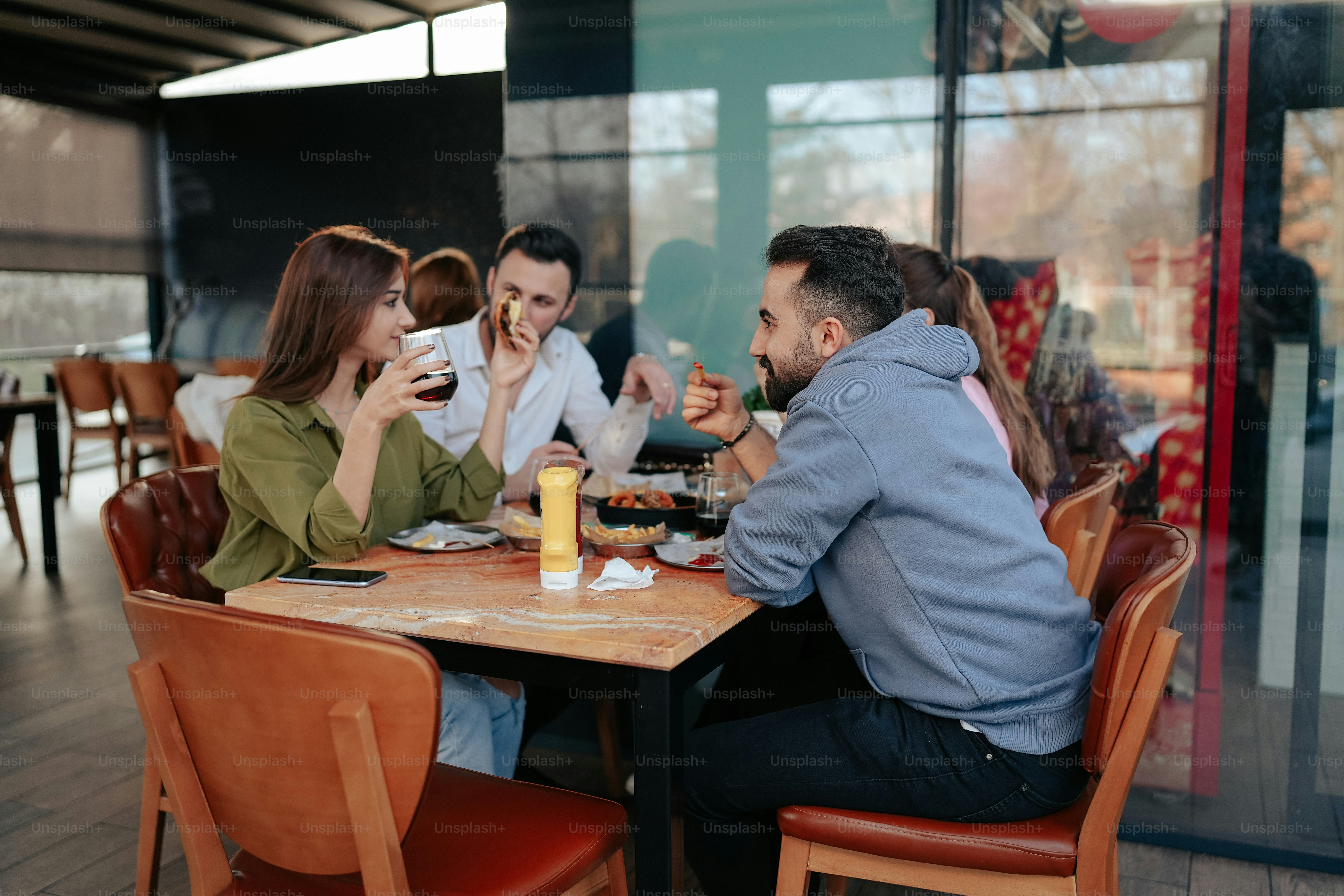 Un groupe de personnes assises autour d’une table en bois photo ...