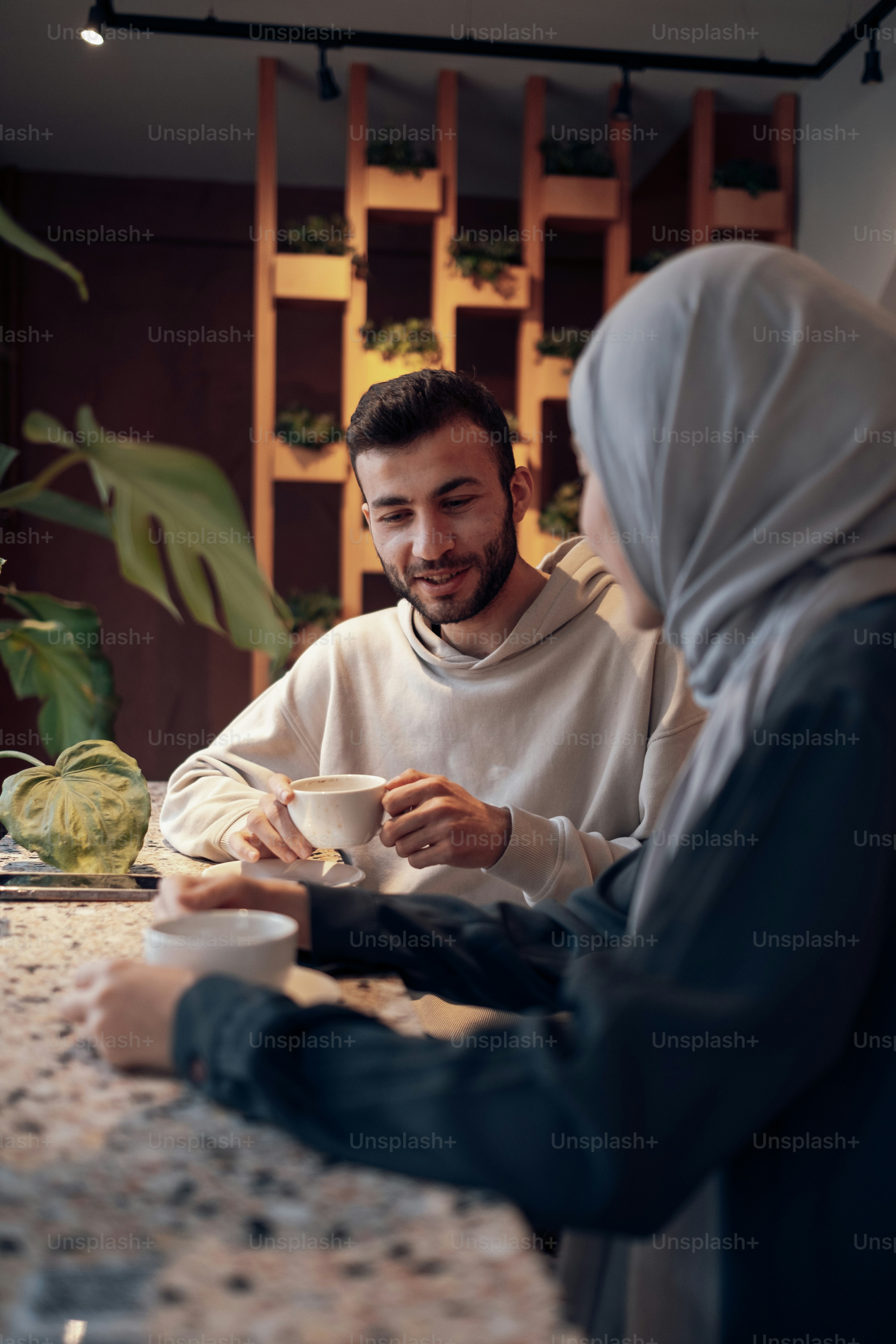 A man and a woman sitting at a table photo – Talking Image on Unsplash