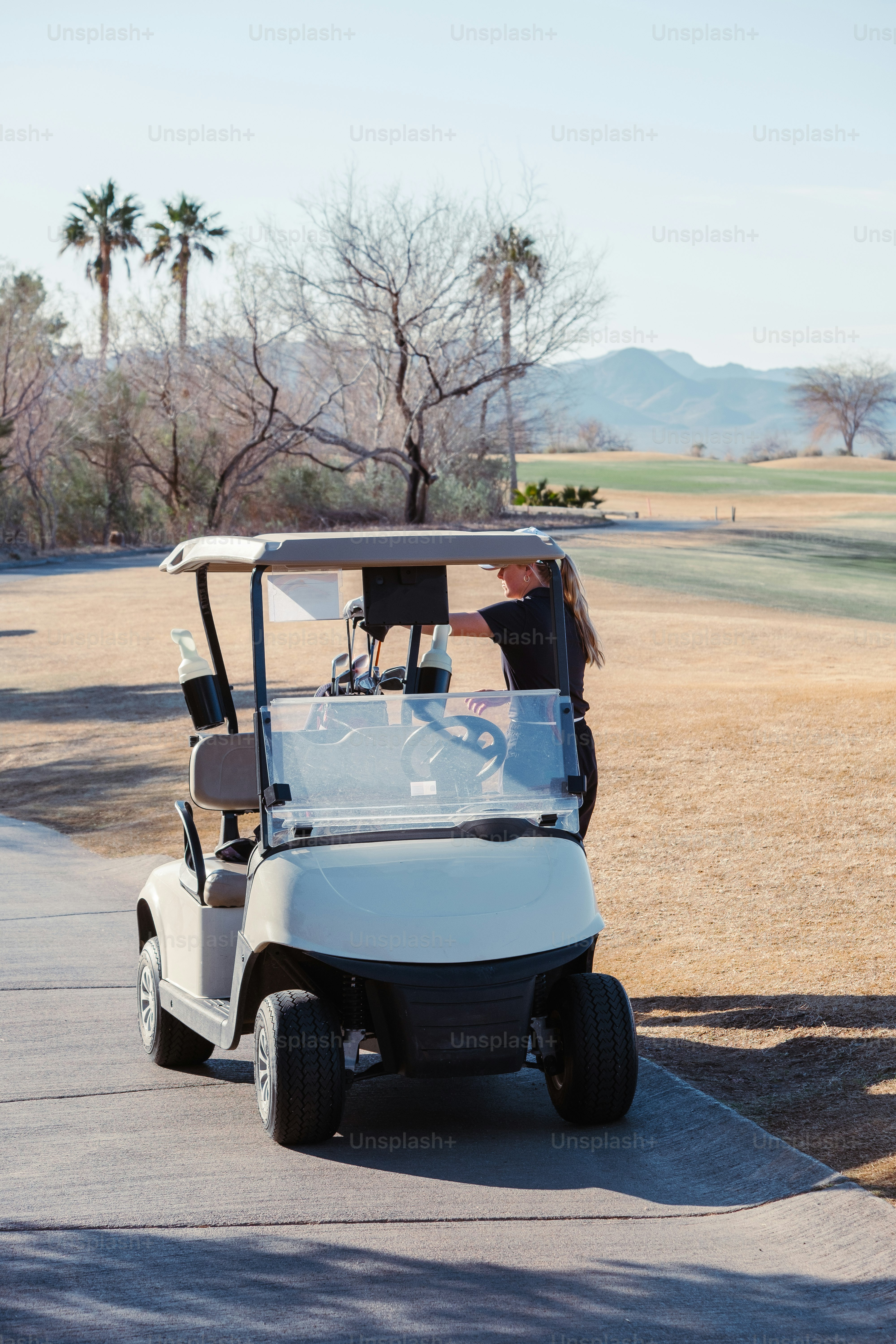 A man driving a golf cart down a street photo – Golfing Image on Unsplash