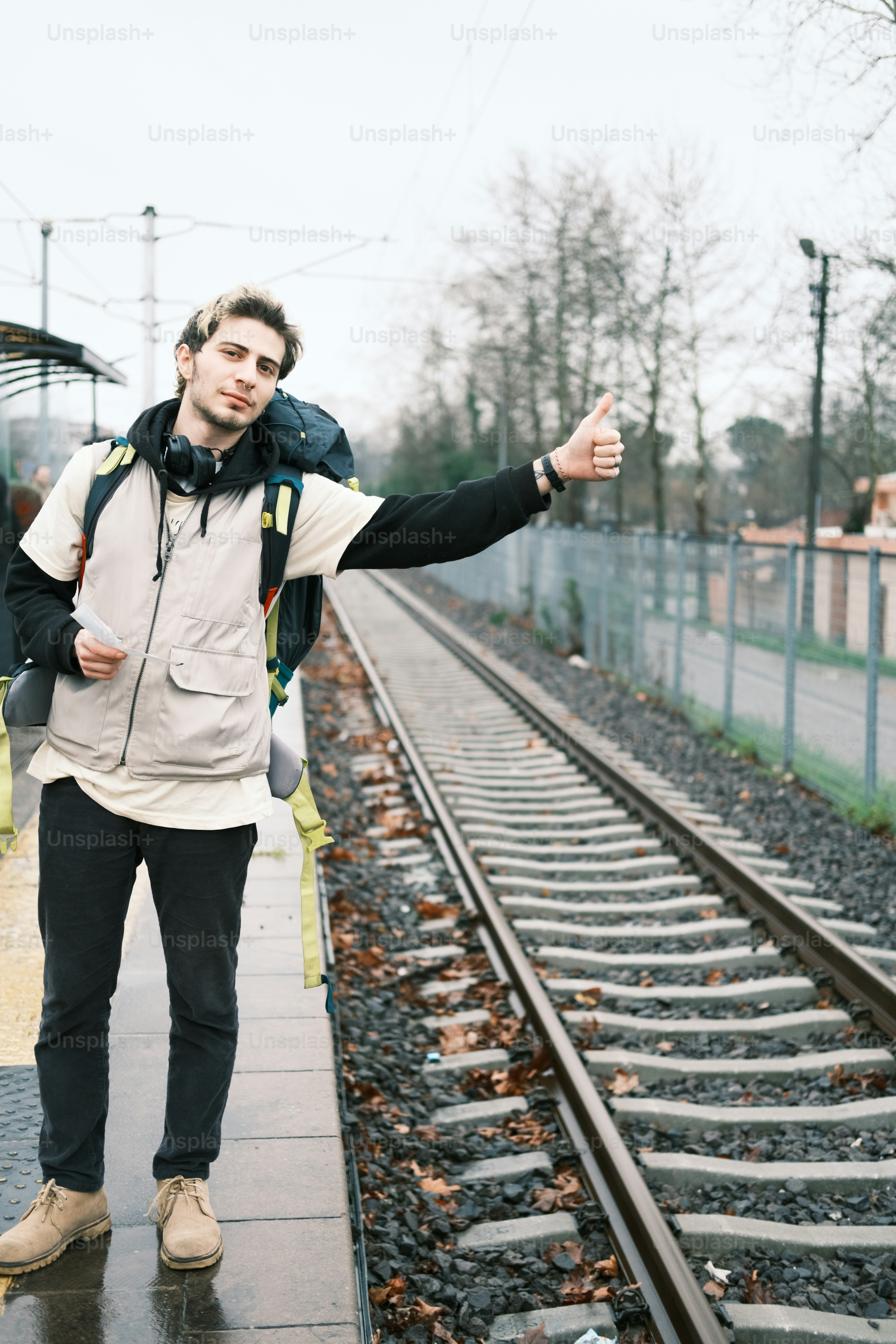 A man standing on a train track giving a thumbs up photo – Train ...