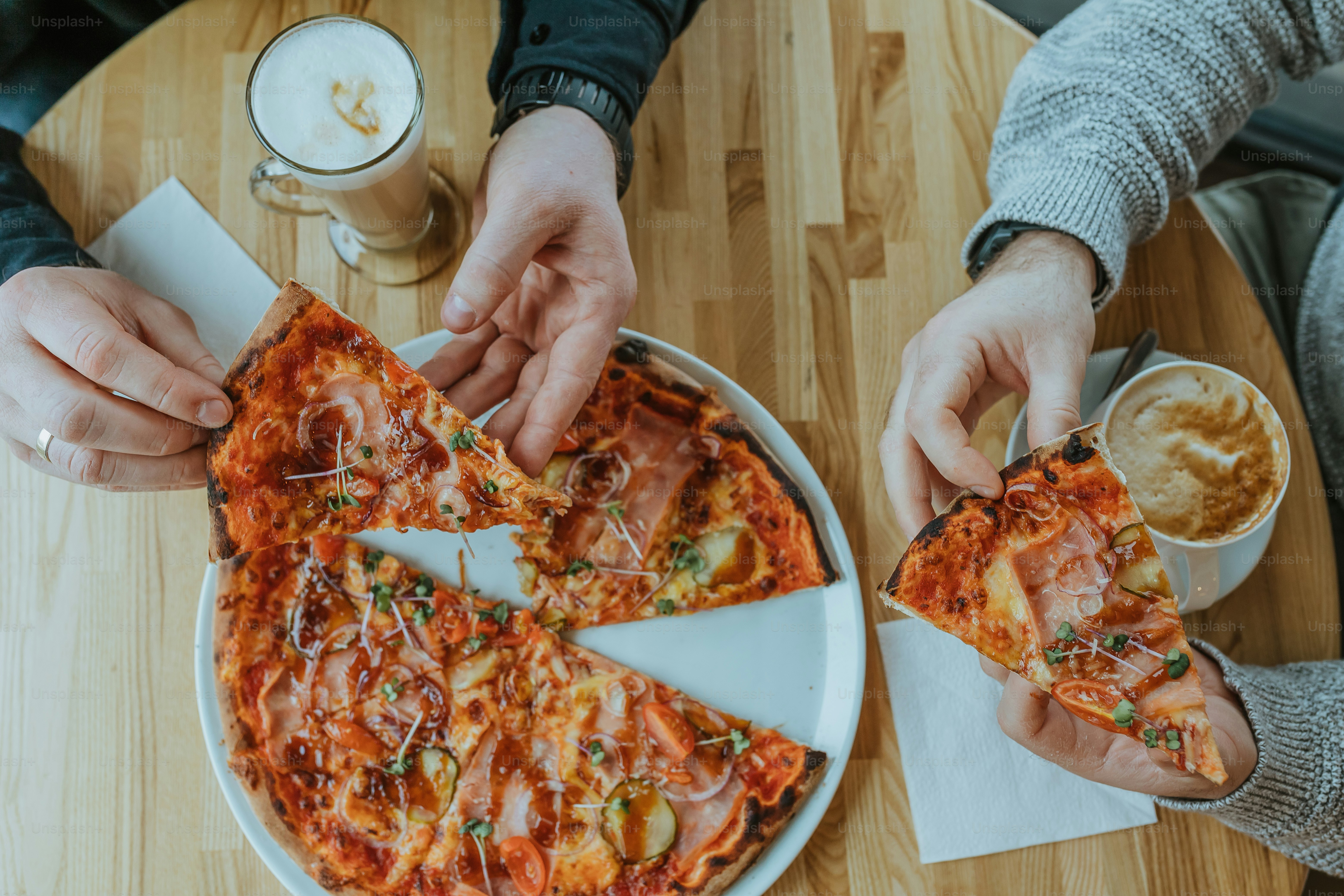 Un par de personas que están comiendo algo de pizza foto – Imagen de ...