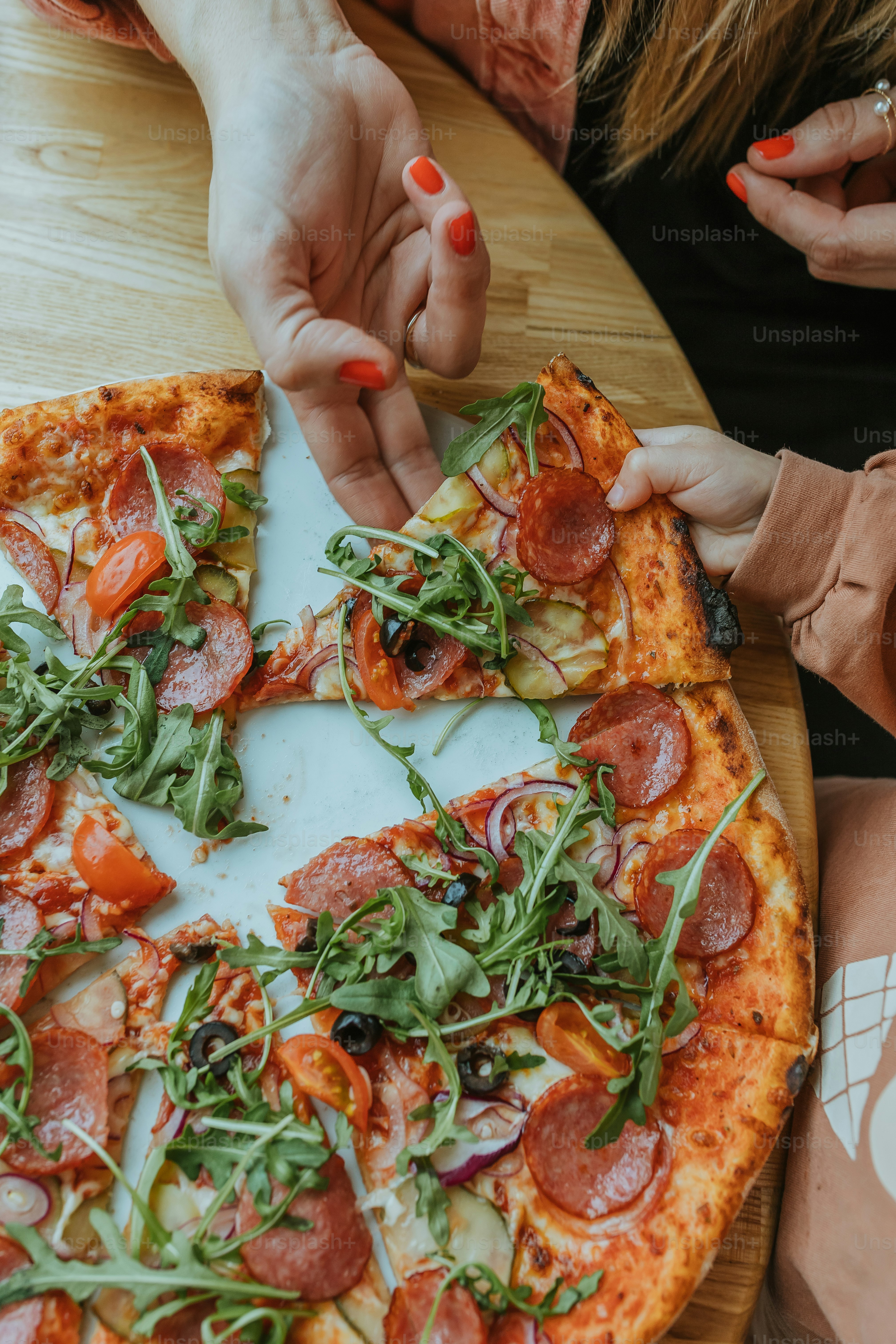 A pizza sitting on top of a wooden table photo – Dinner with friends ...