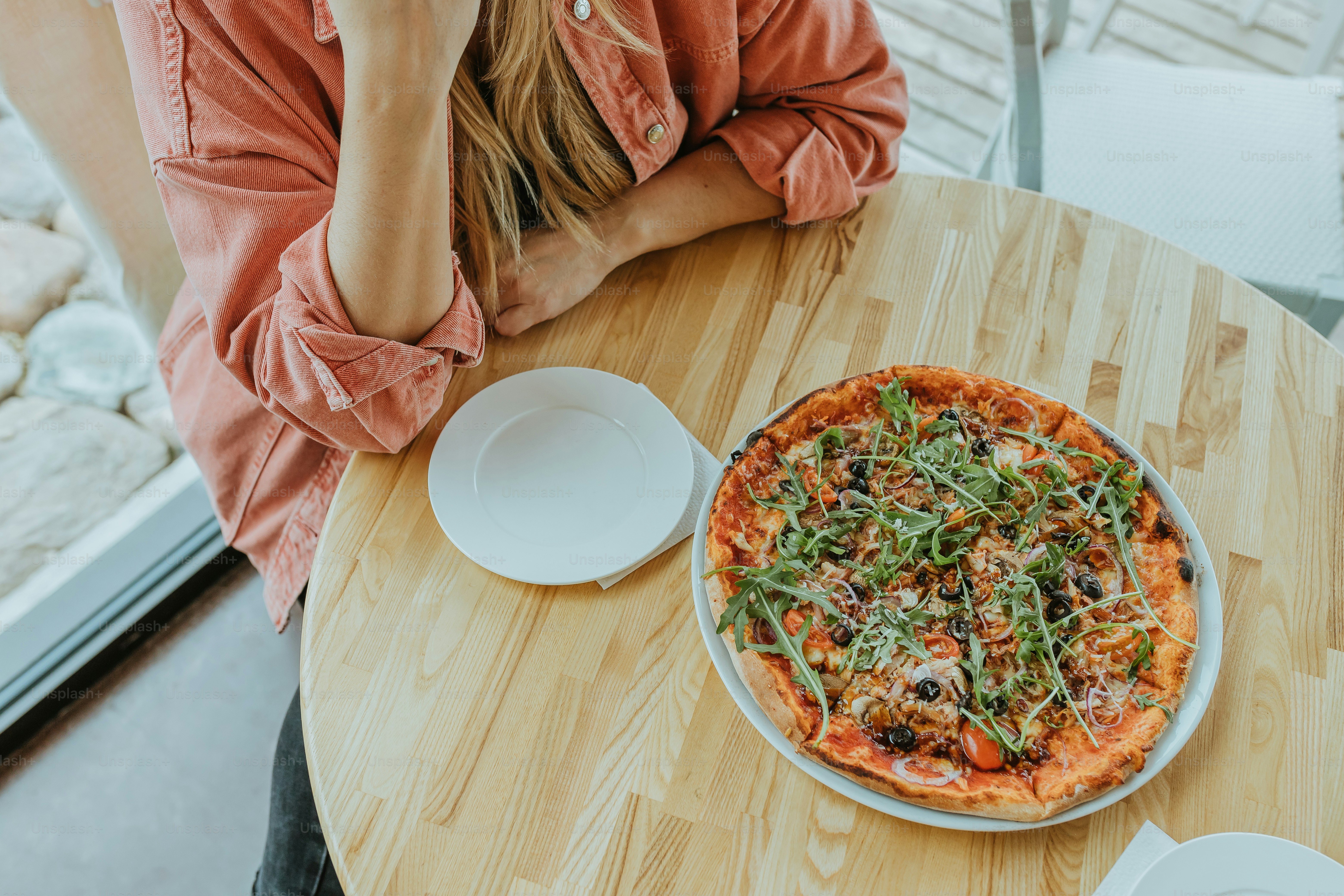 A group of people sitting around a table with pizza photo – Dinner ...