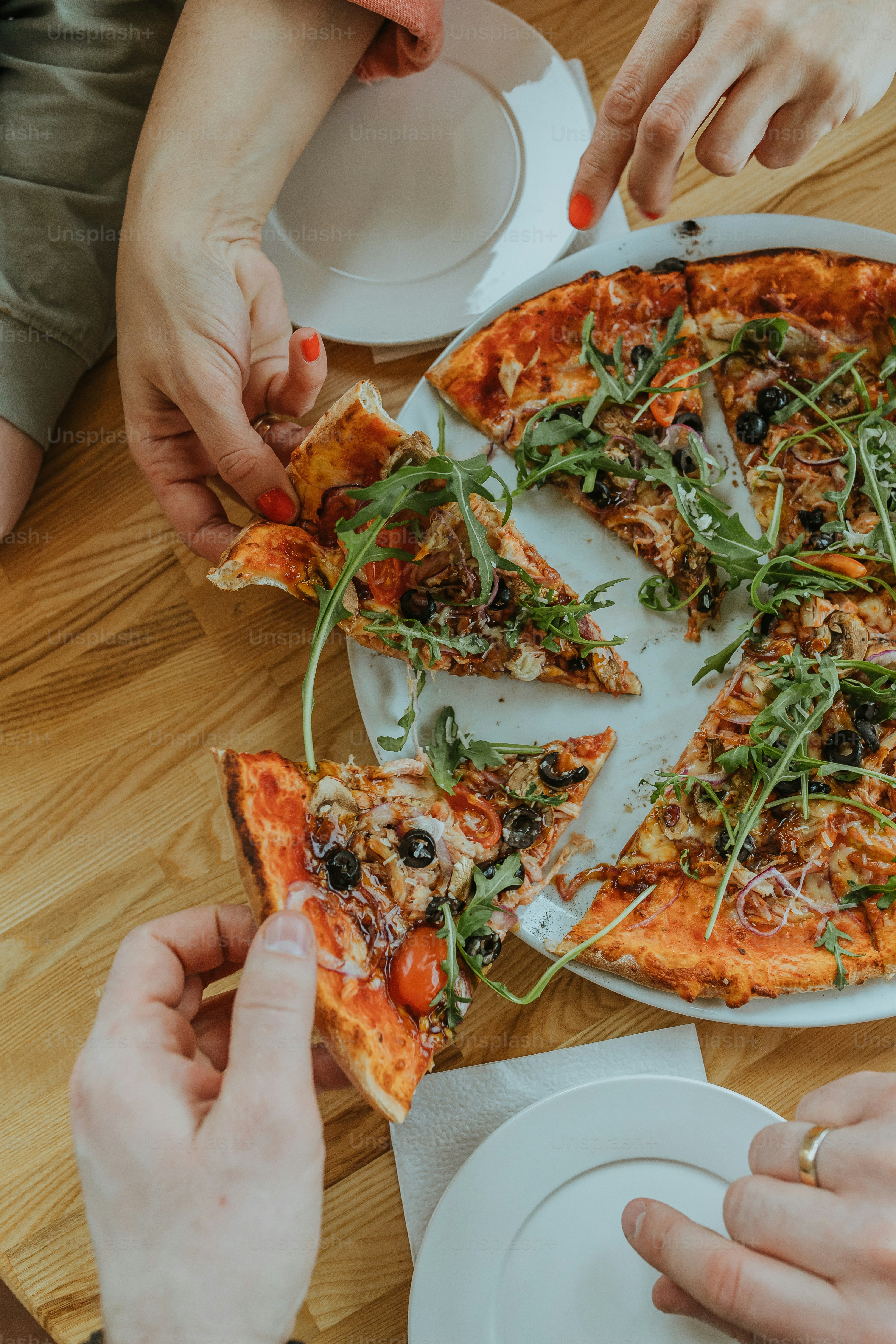A woman sitting at a table eating a slice of pizza photo – Slice of ...