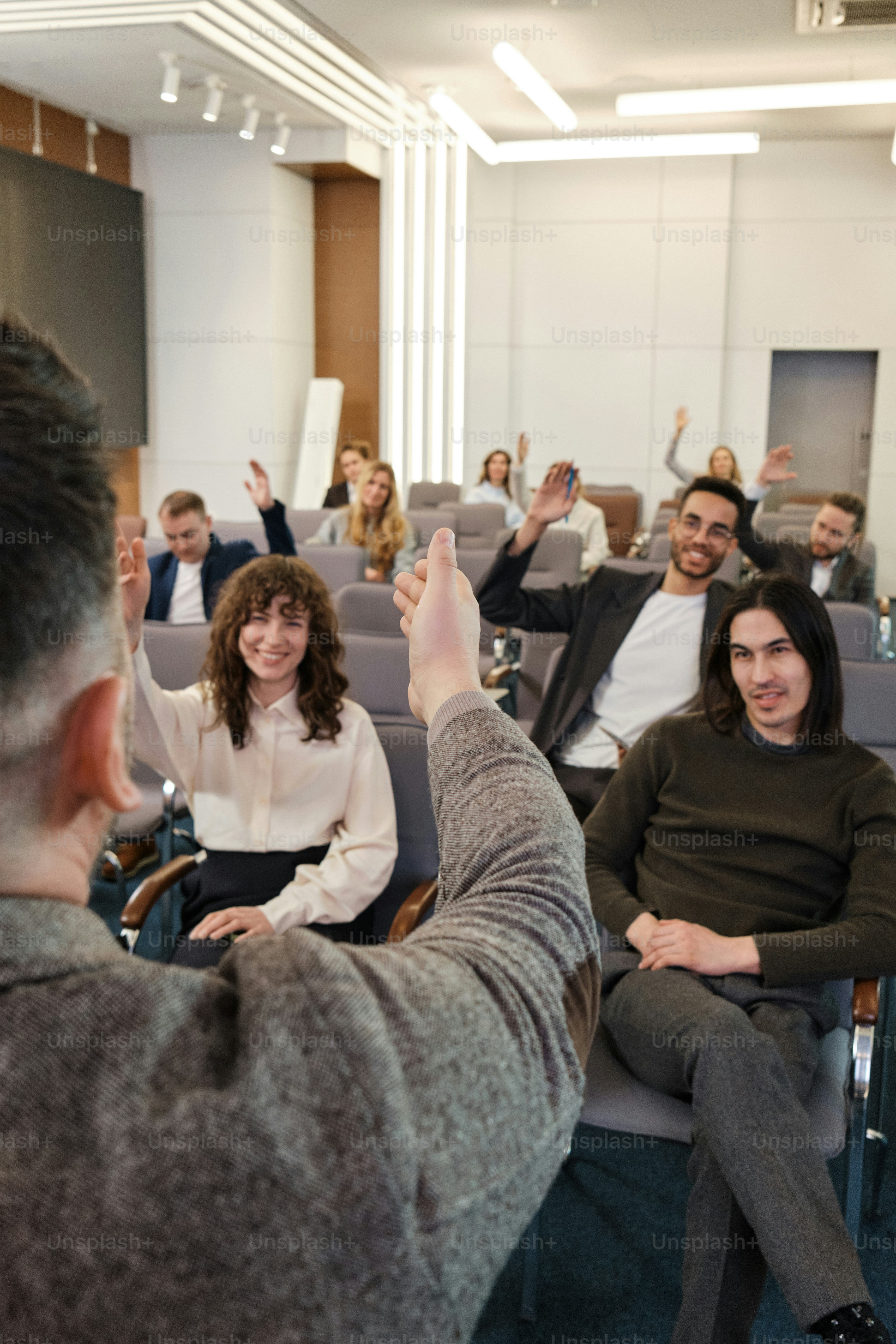 A group of people sitting in chairs in a room photo – Audience Image on ...