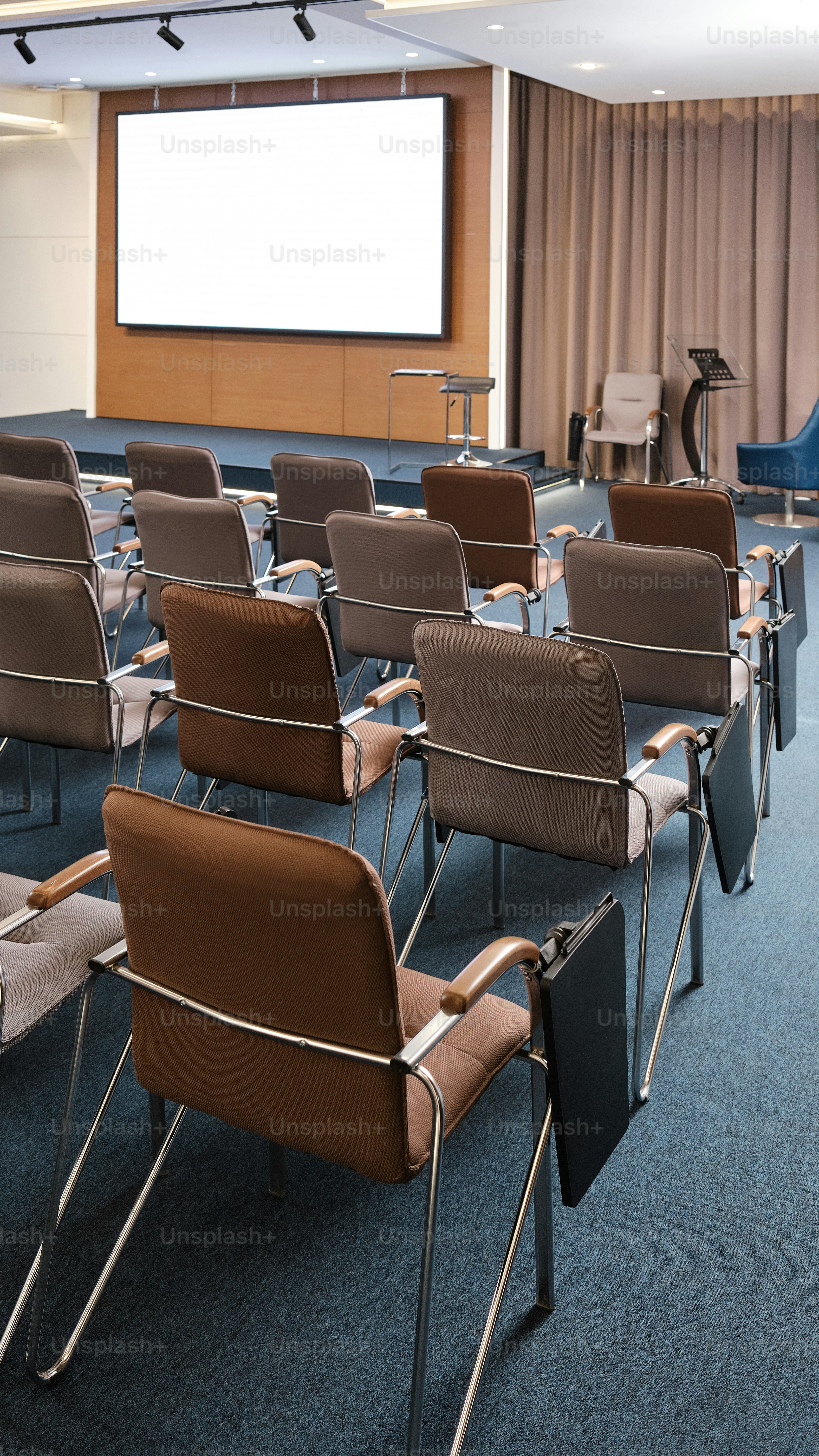 A group of people sitting in chairs in front of a projector screen ...