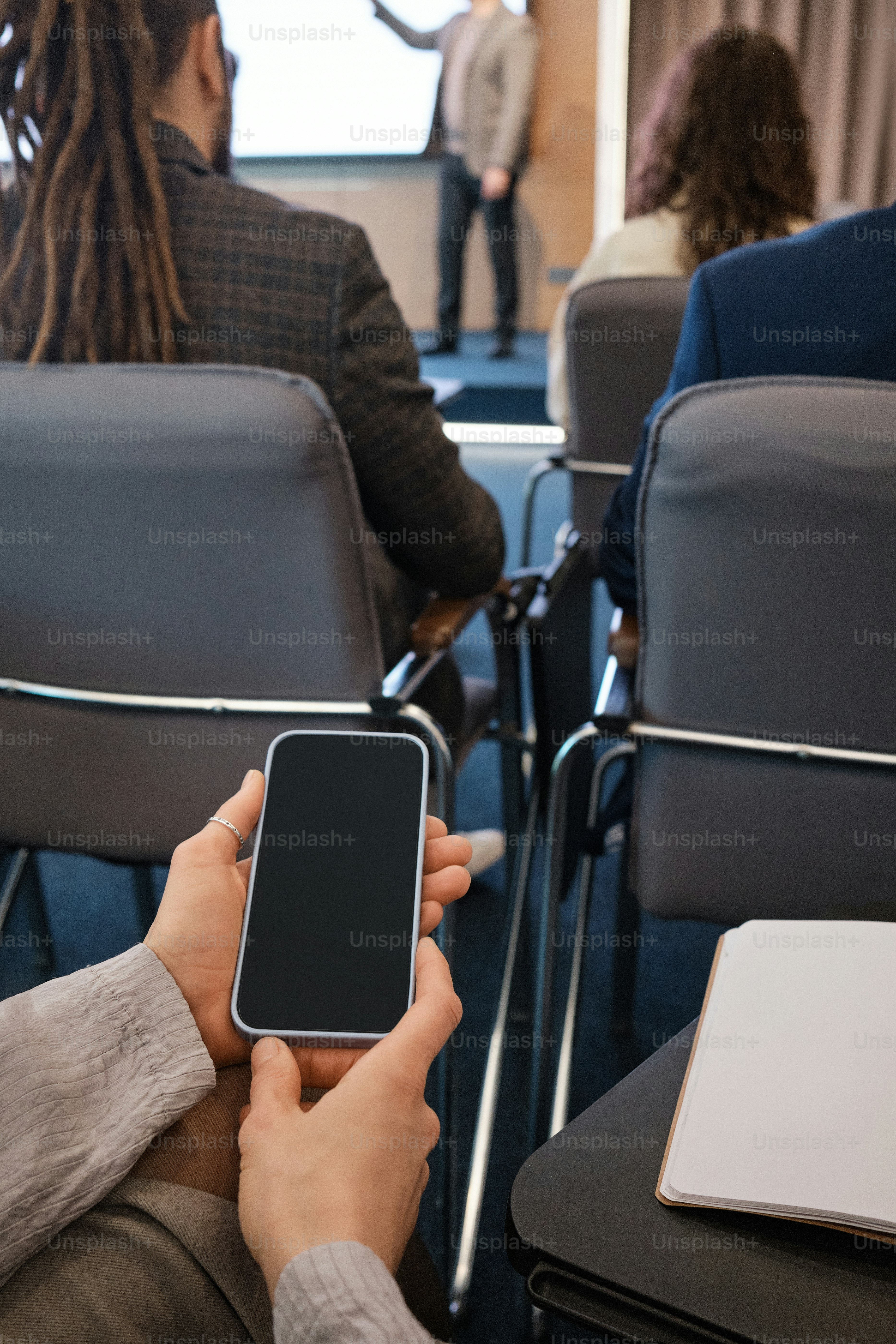 Une personne assise sur une chaise tenant un téléphone cellulaire photo ...