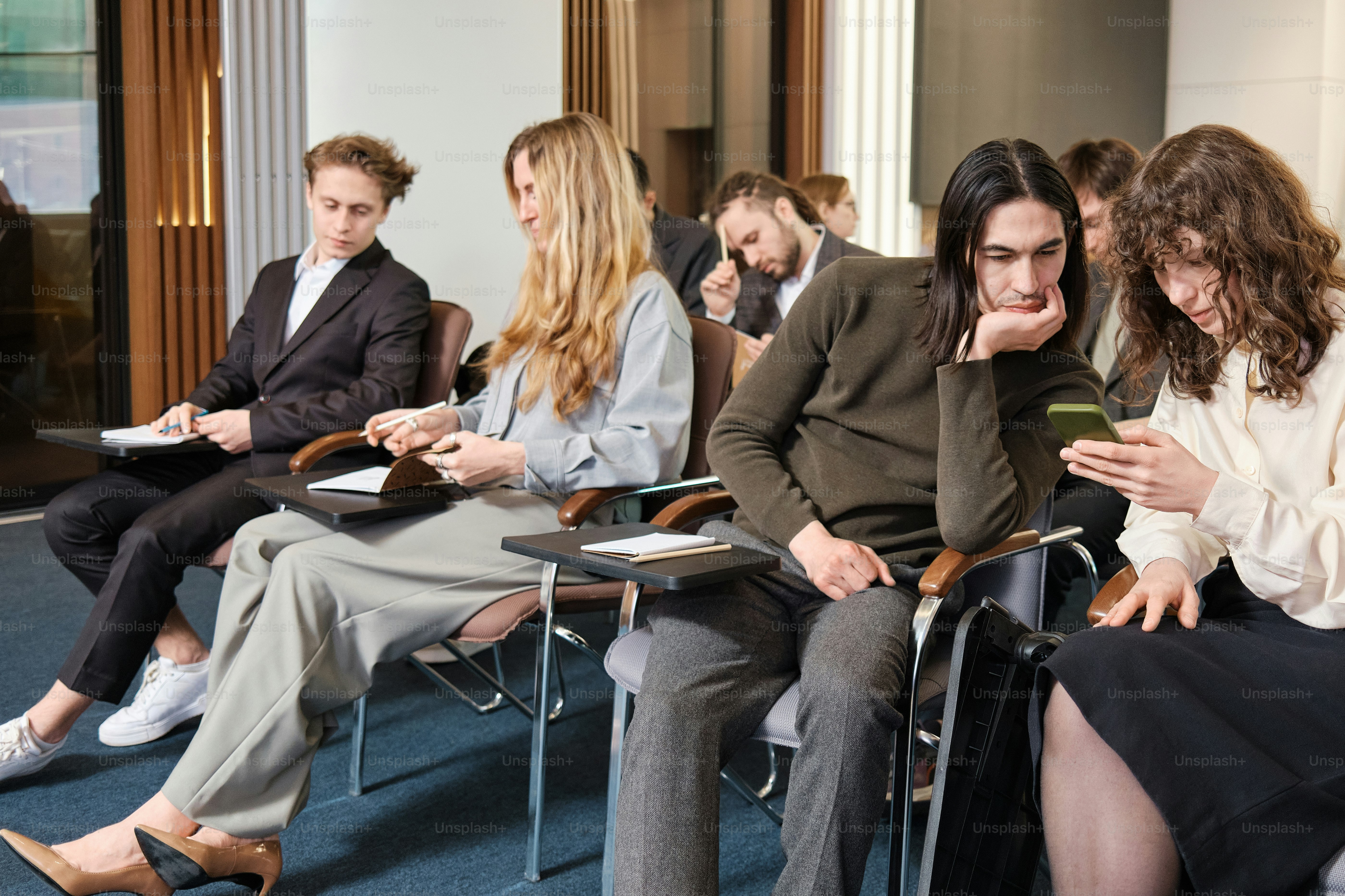 A group of people sitting next to each other photo – Education Image on ...