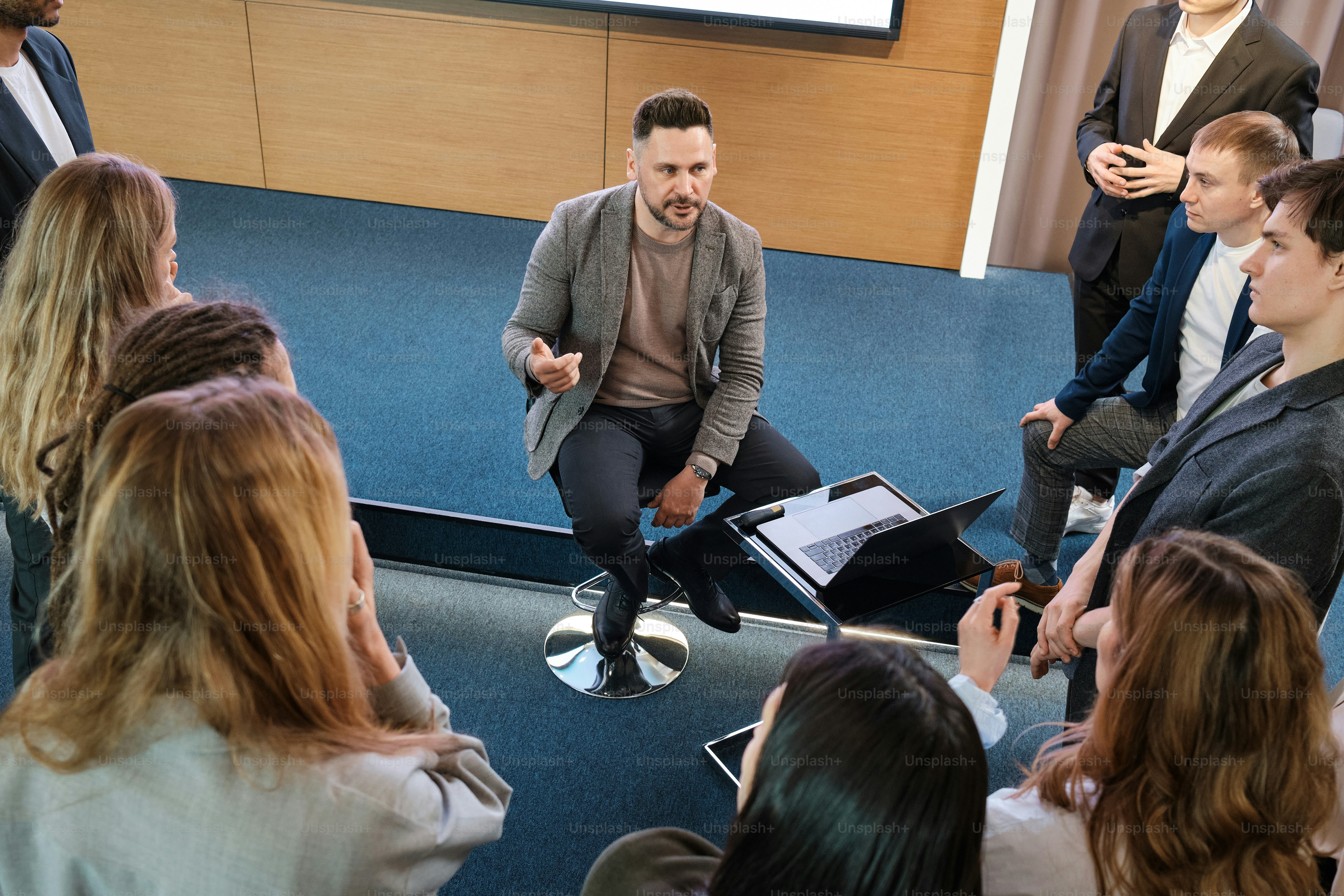 Un groupe de personnes assises autour d’une table en train de parler ...