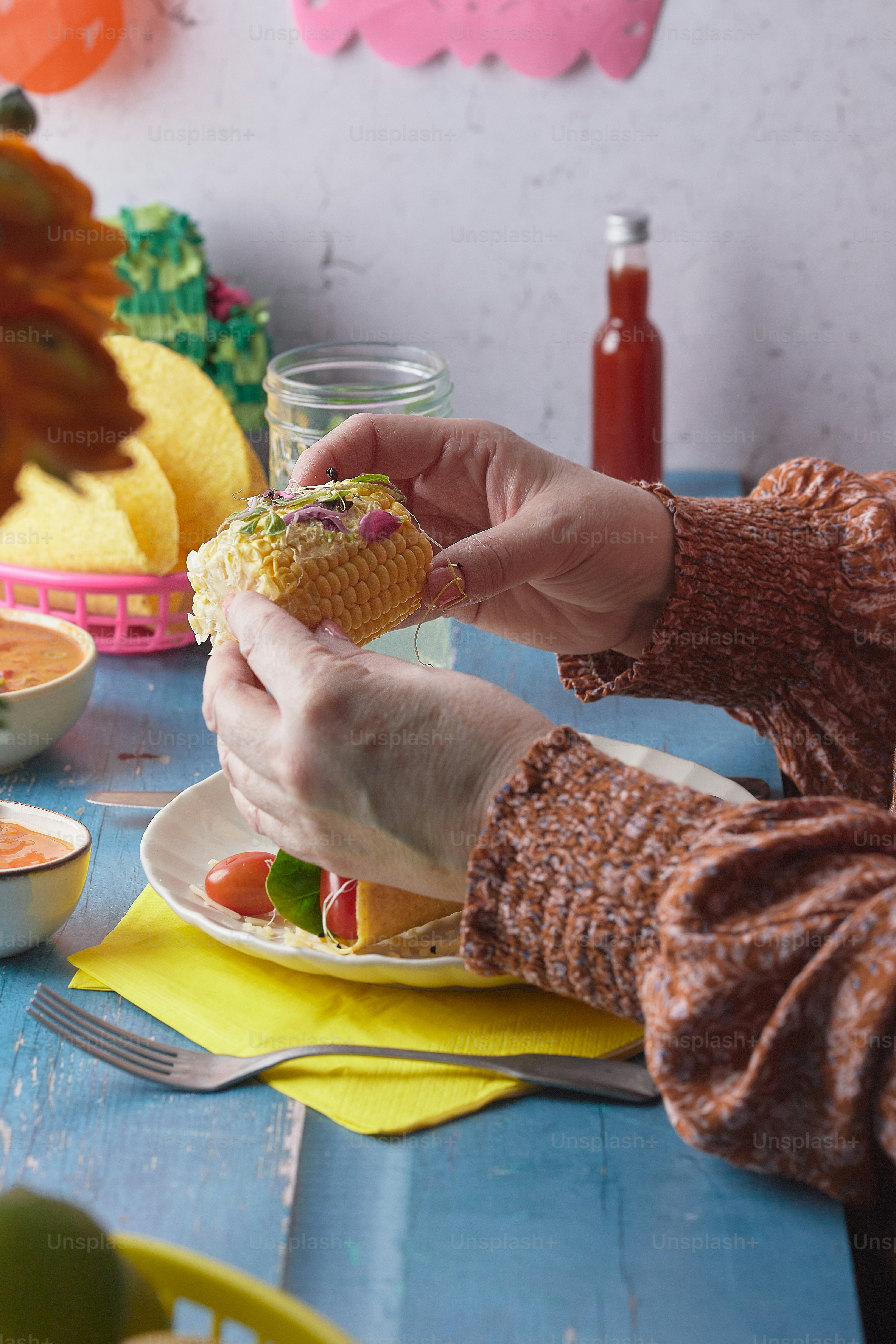 A woman is eating a corn on the cob photo – Cinco de mayo Image on Unsplash