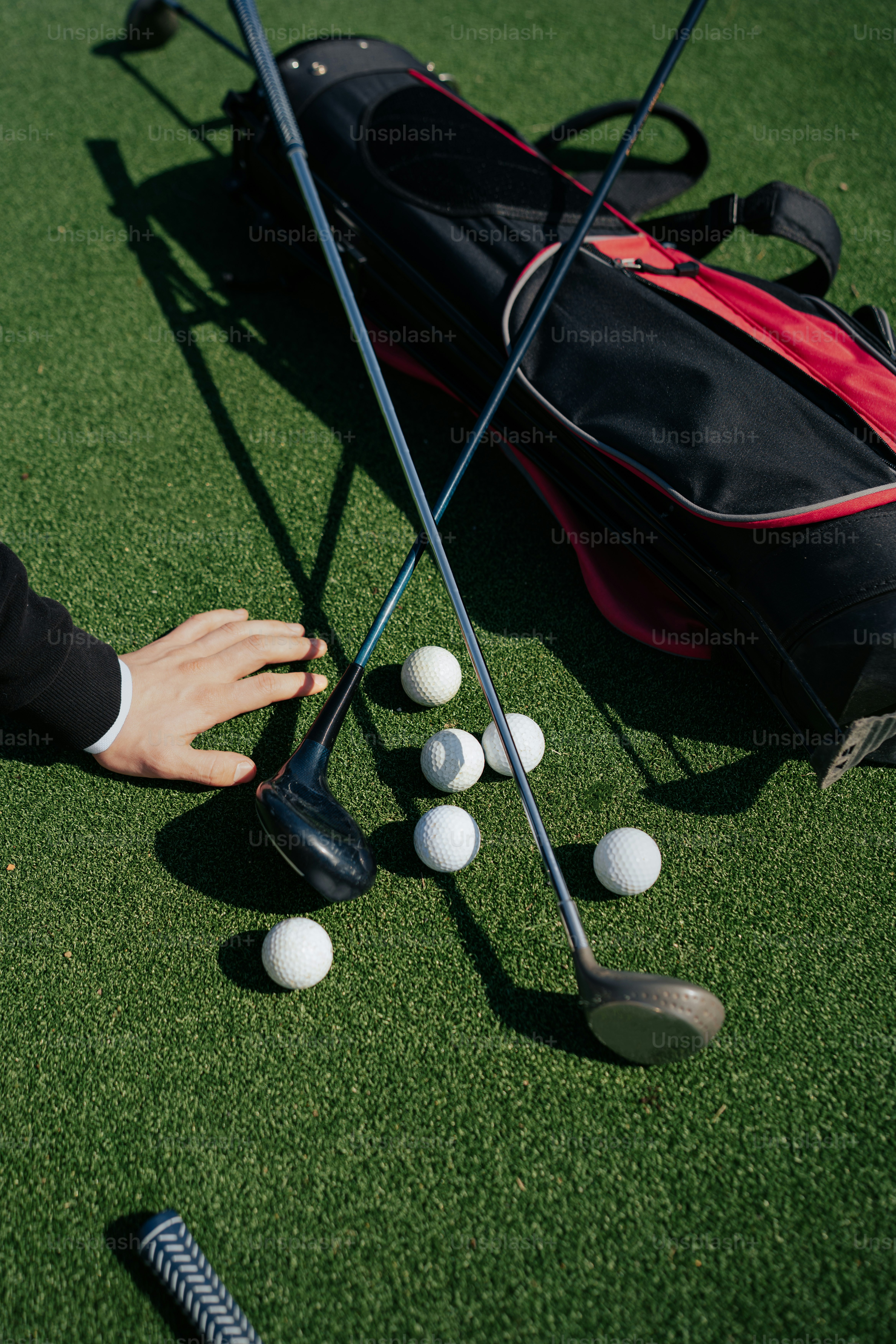 A group of golf balls sitting on top of a green field photo – Golfing ...