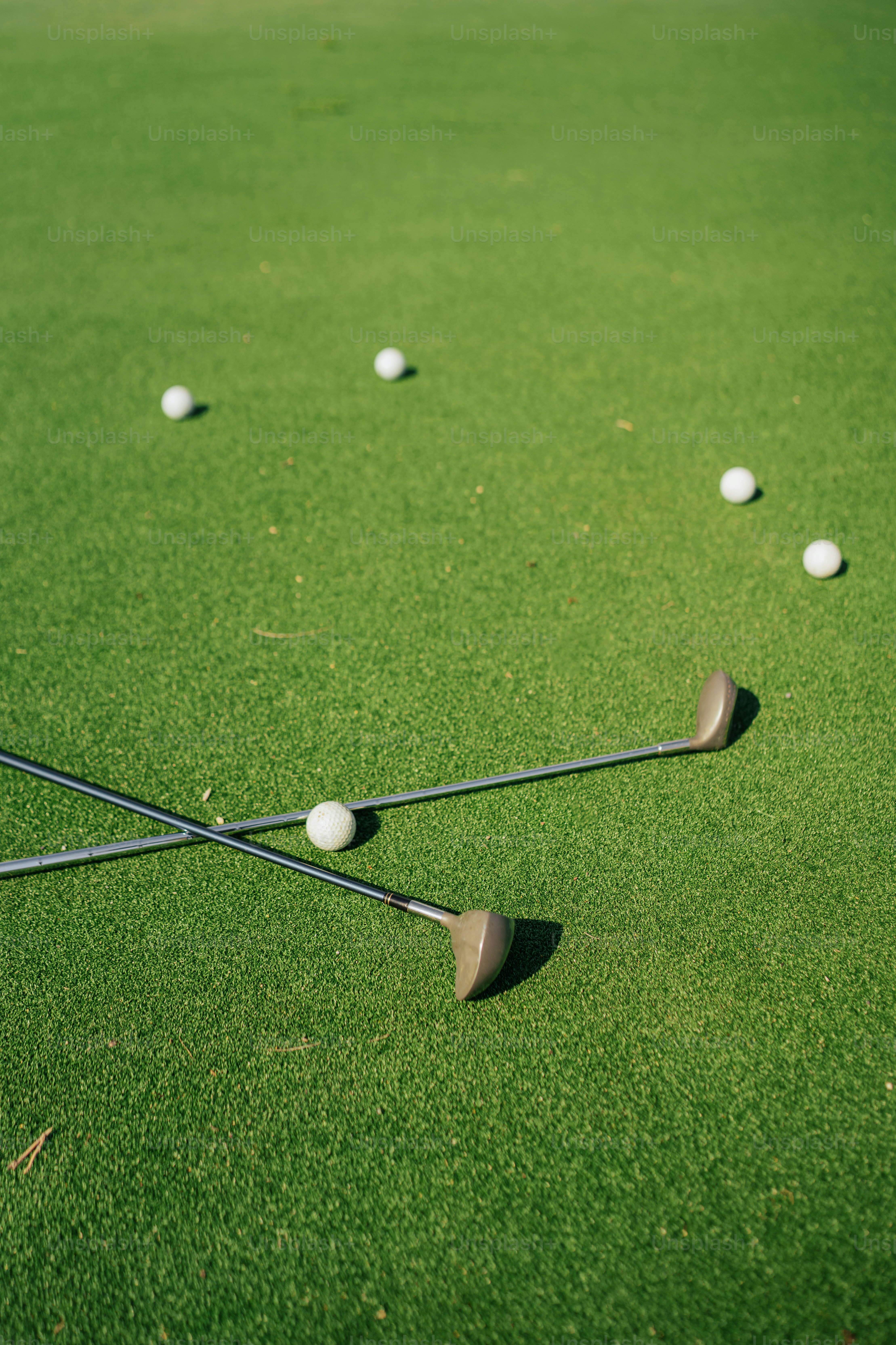 A group of golf balls sitting on top of a green field photo – Golfing ...