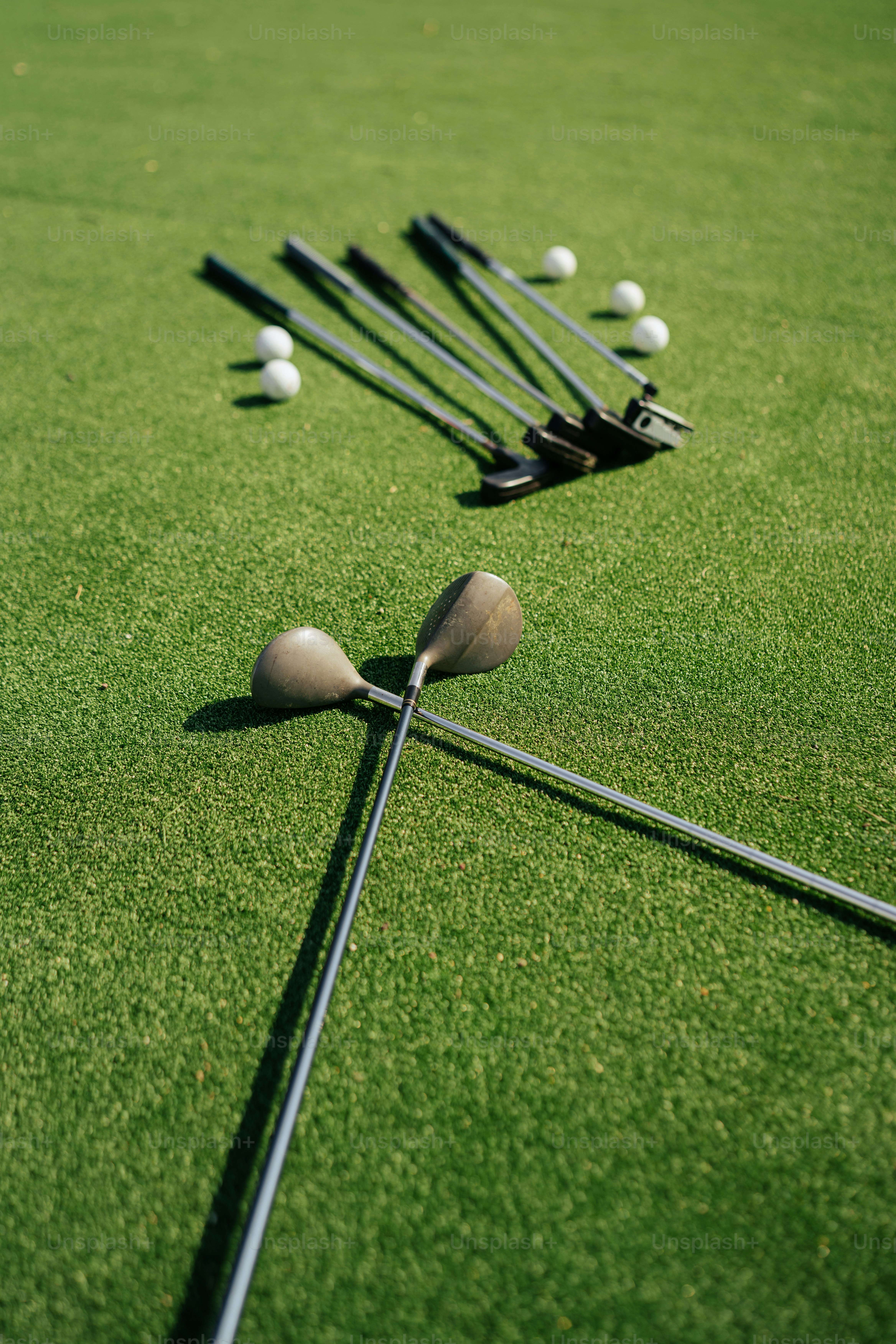 A group of golf clubs and balls laying on the grass photo – Golf club ...