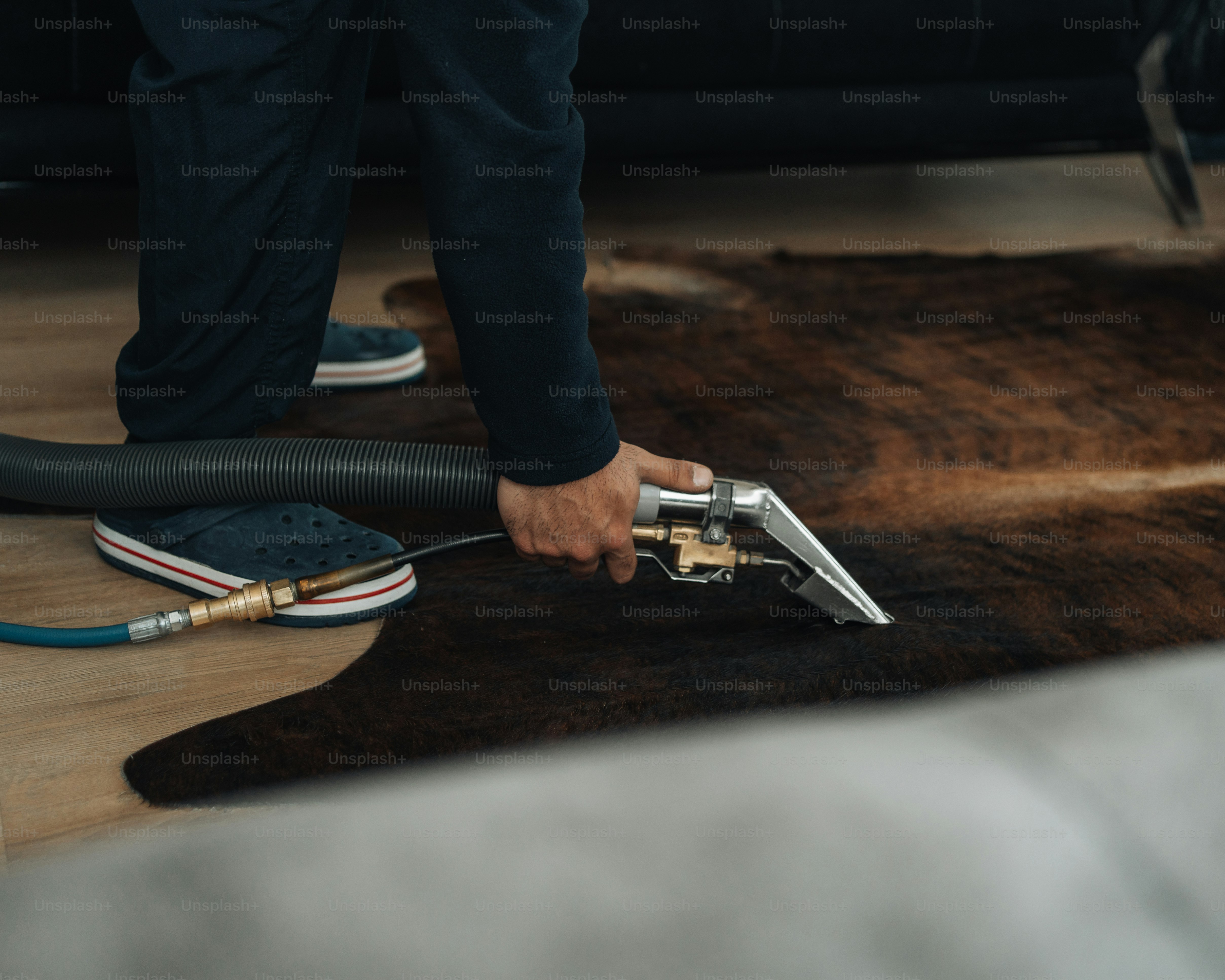 A person vacuuming a rug with a vacuum cleaner photo – Cleaning Image ...