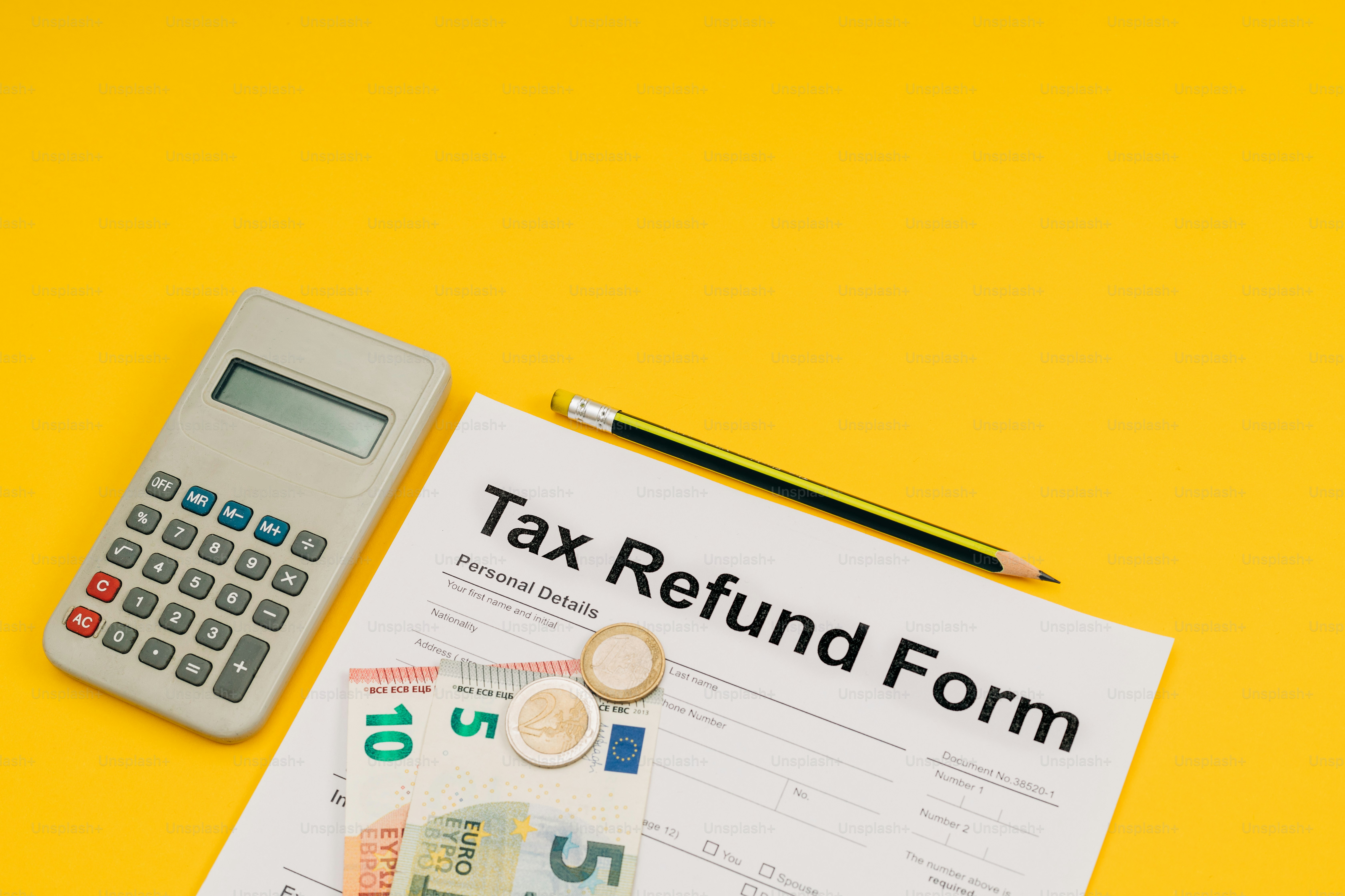 A tax refund form next to a calculator and a pen photo – Finance Image ...